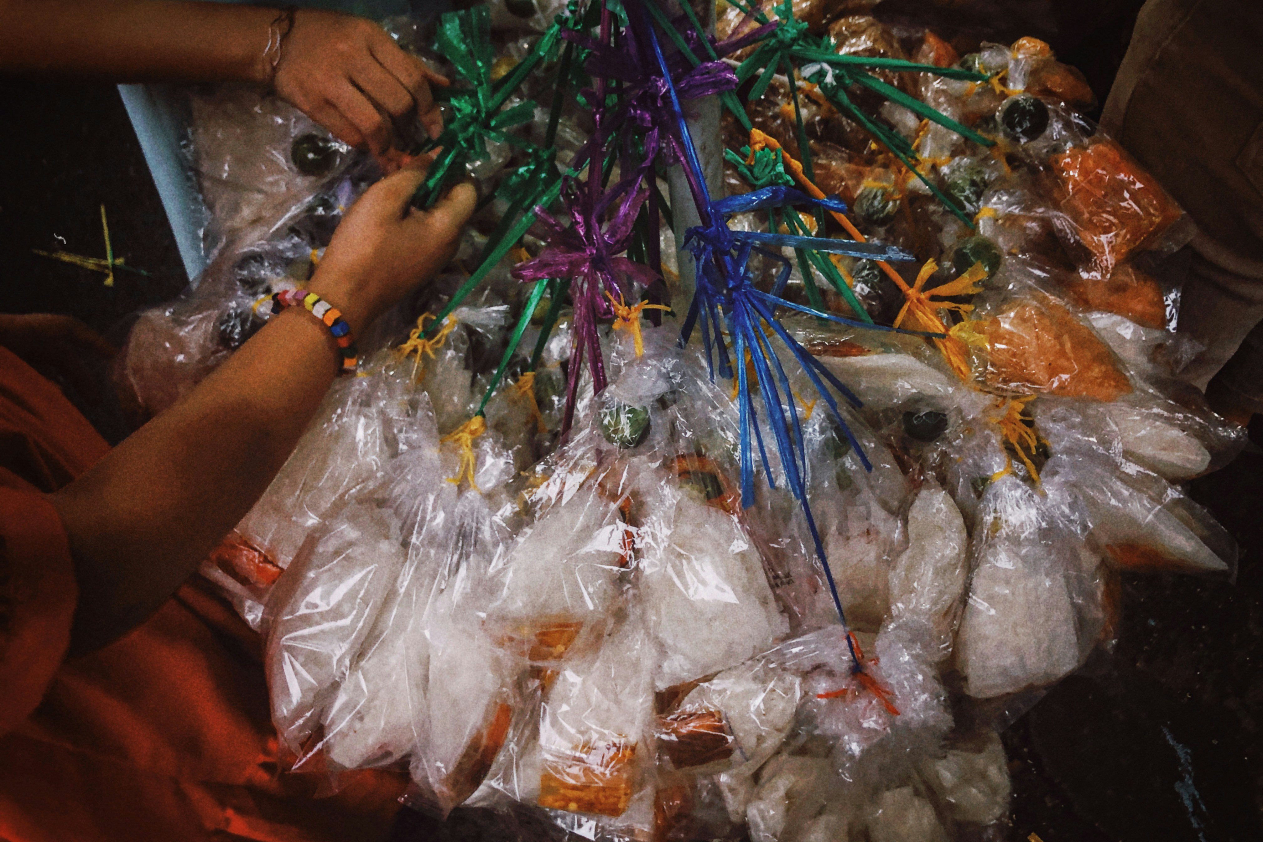 A person holding a bunch of plastic bags filled with items photo – Free ...