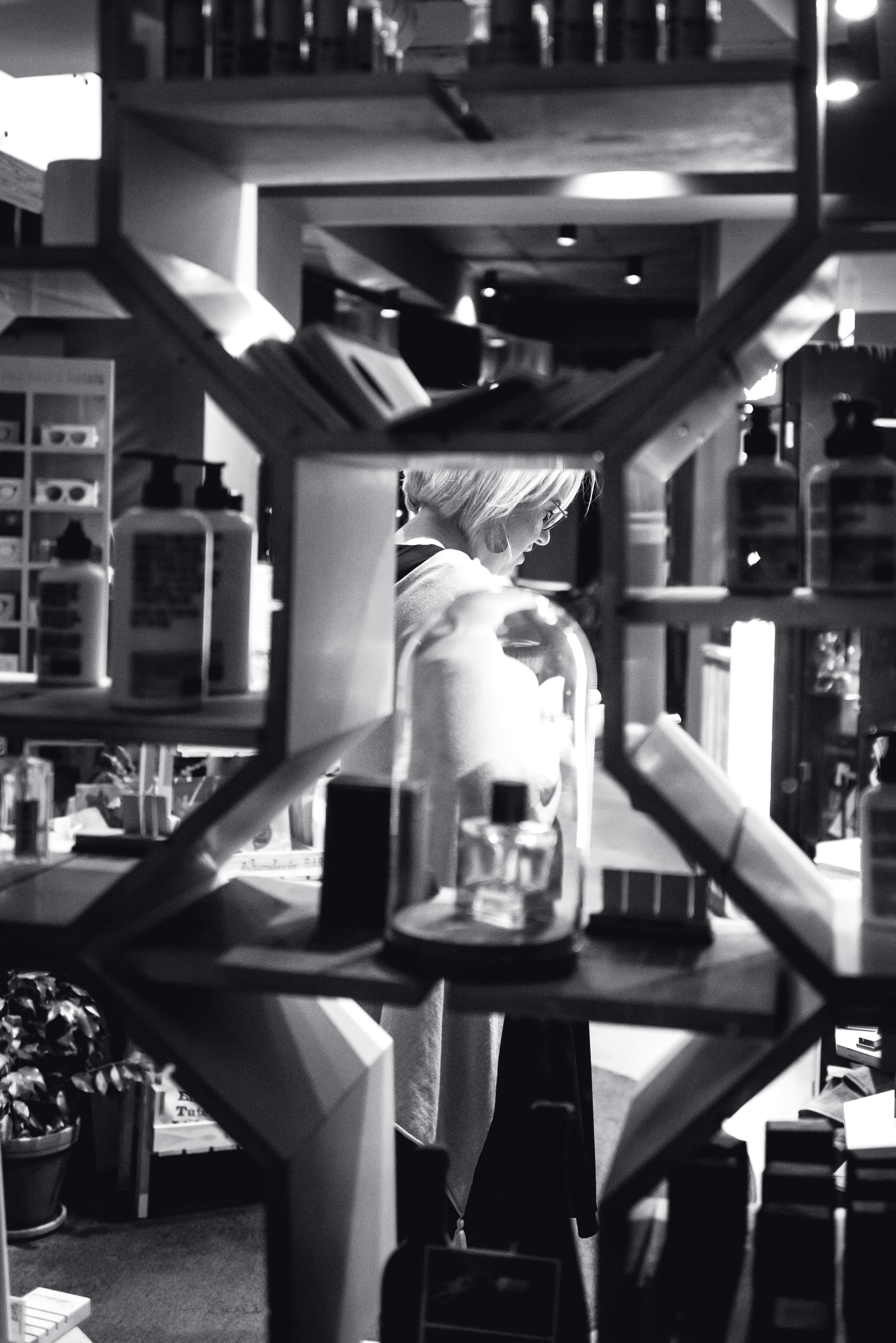 Through the Shelving Frame: A Portrait of Focus in a Quiet Shop
