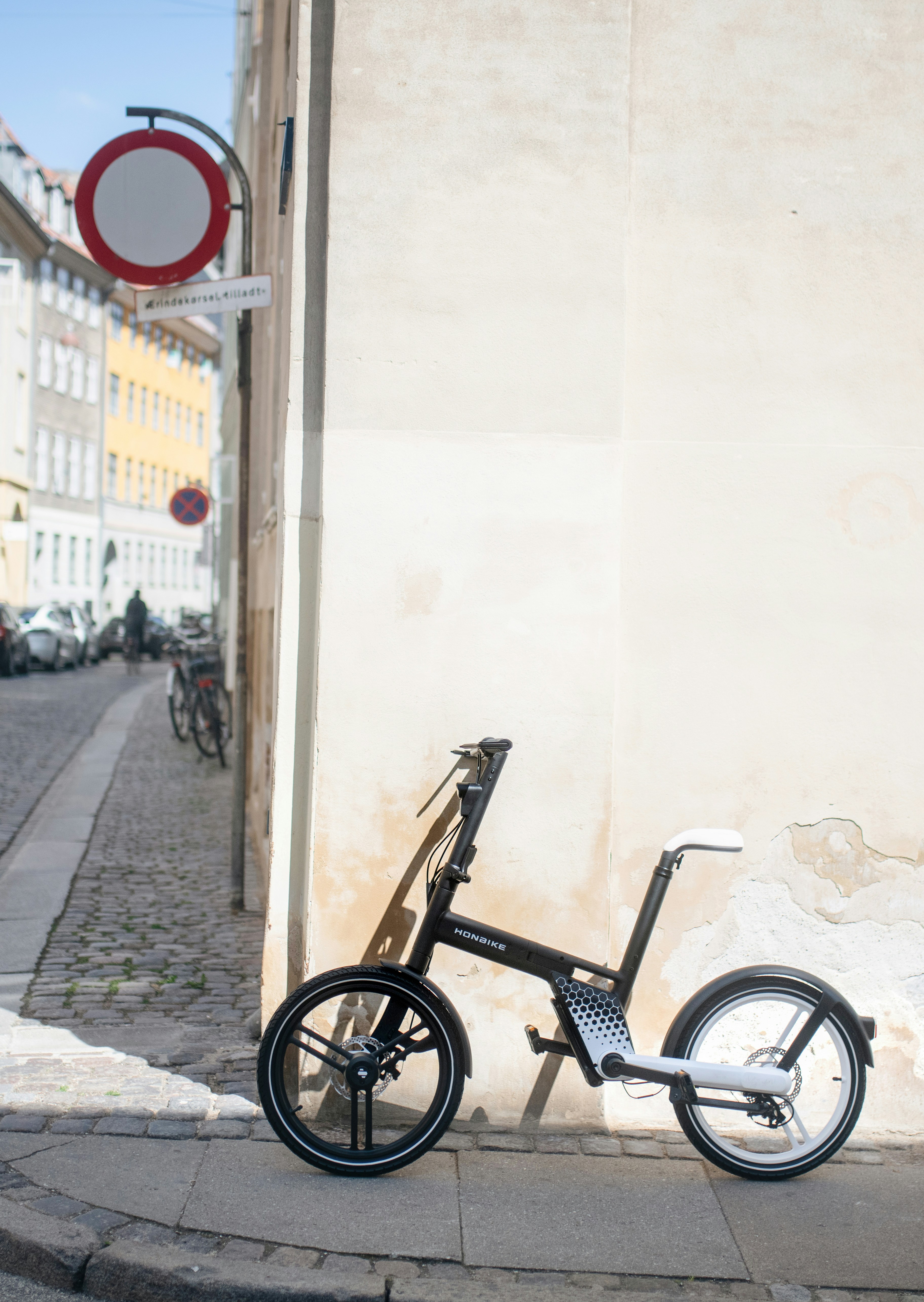 Folded City Silence: A Foldable Bike by a Sunlit Wall