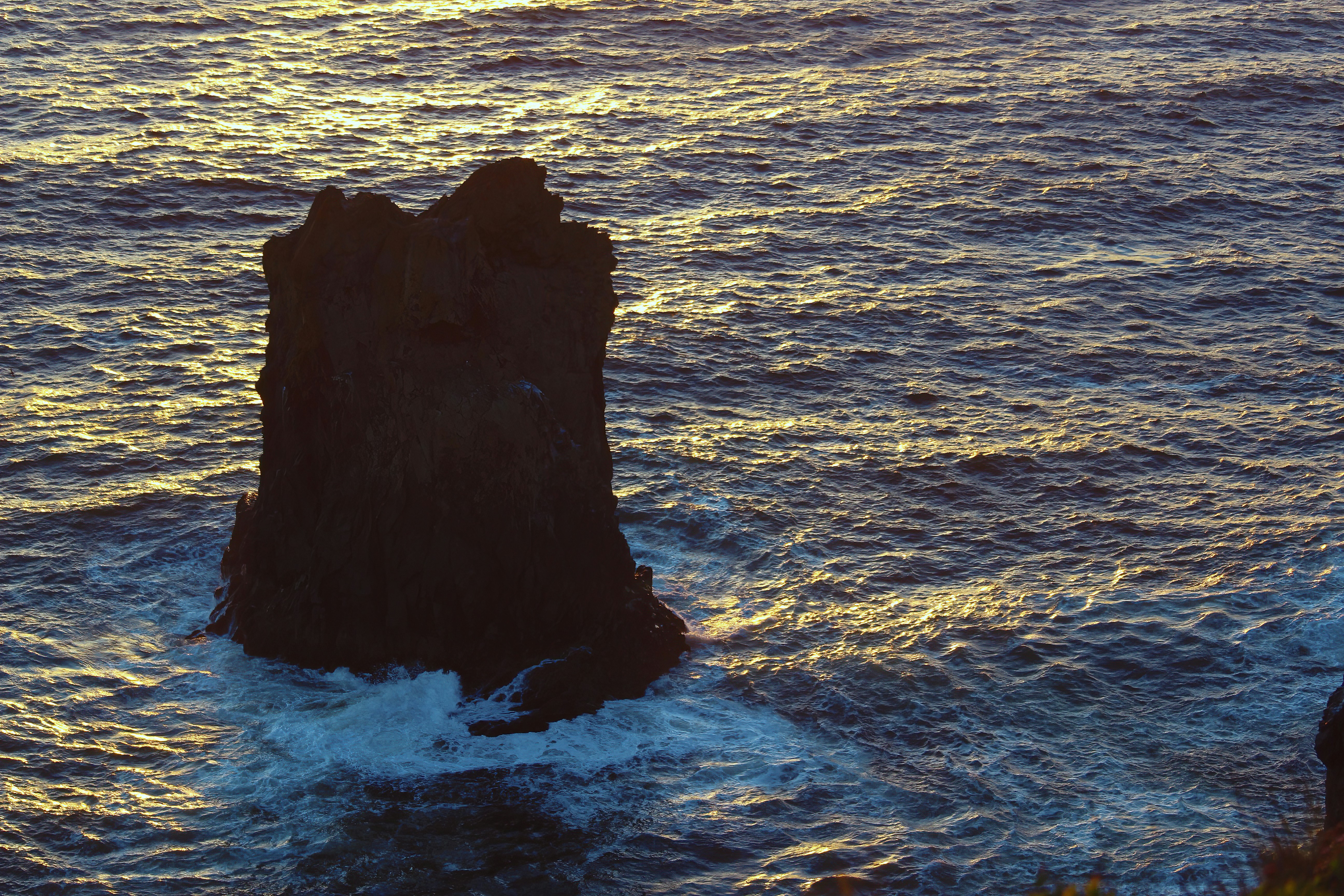 Amber Sentinel: Sea Stack Standing Against Sunset Surges
