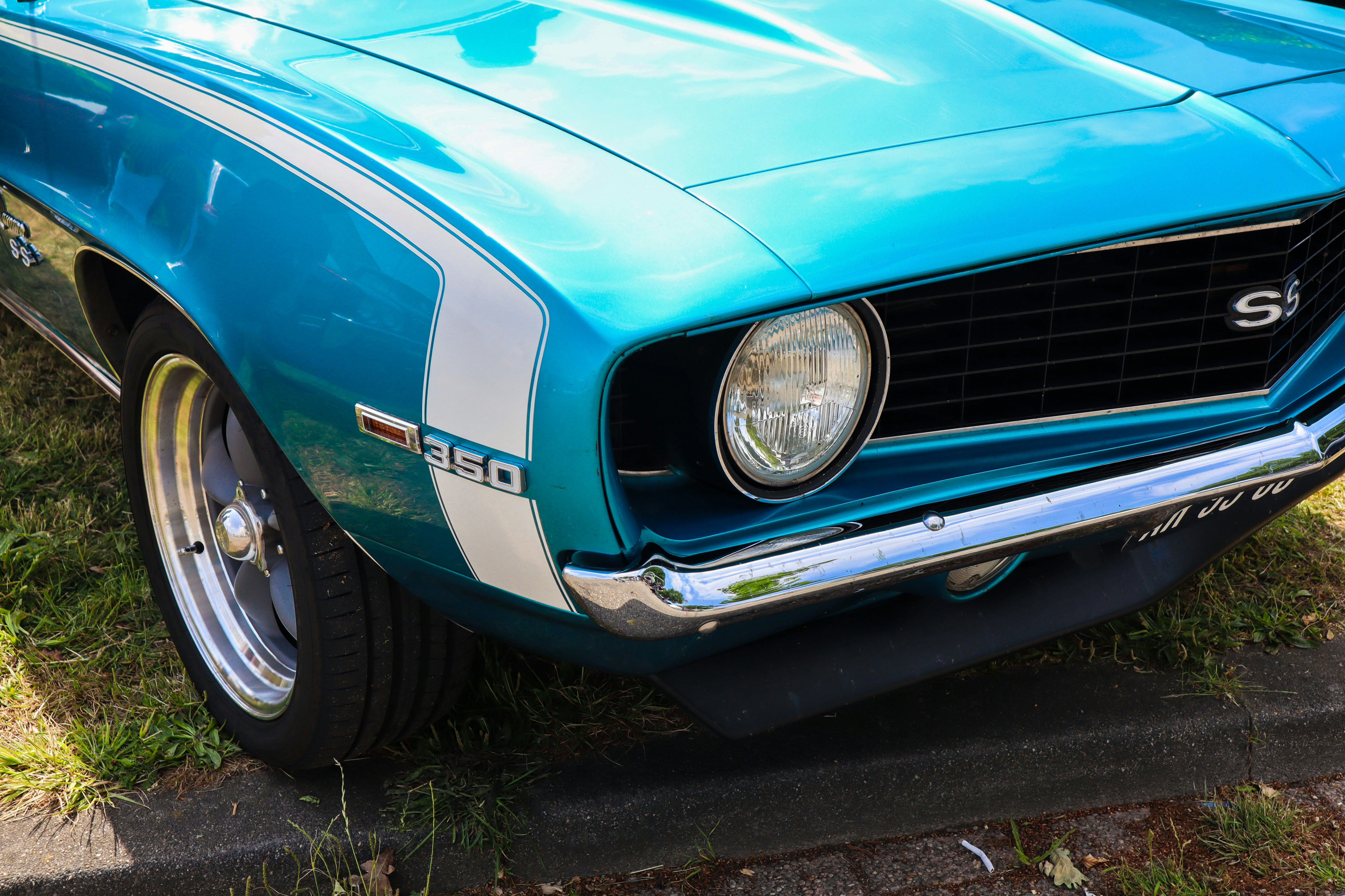 Foto Un muscle car azul y blanco estacionado al costado de la carretera ...