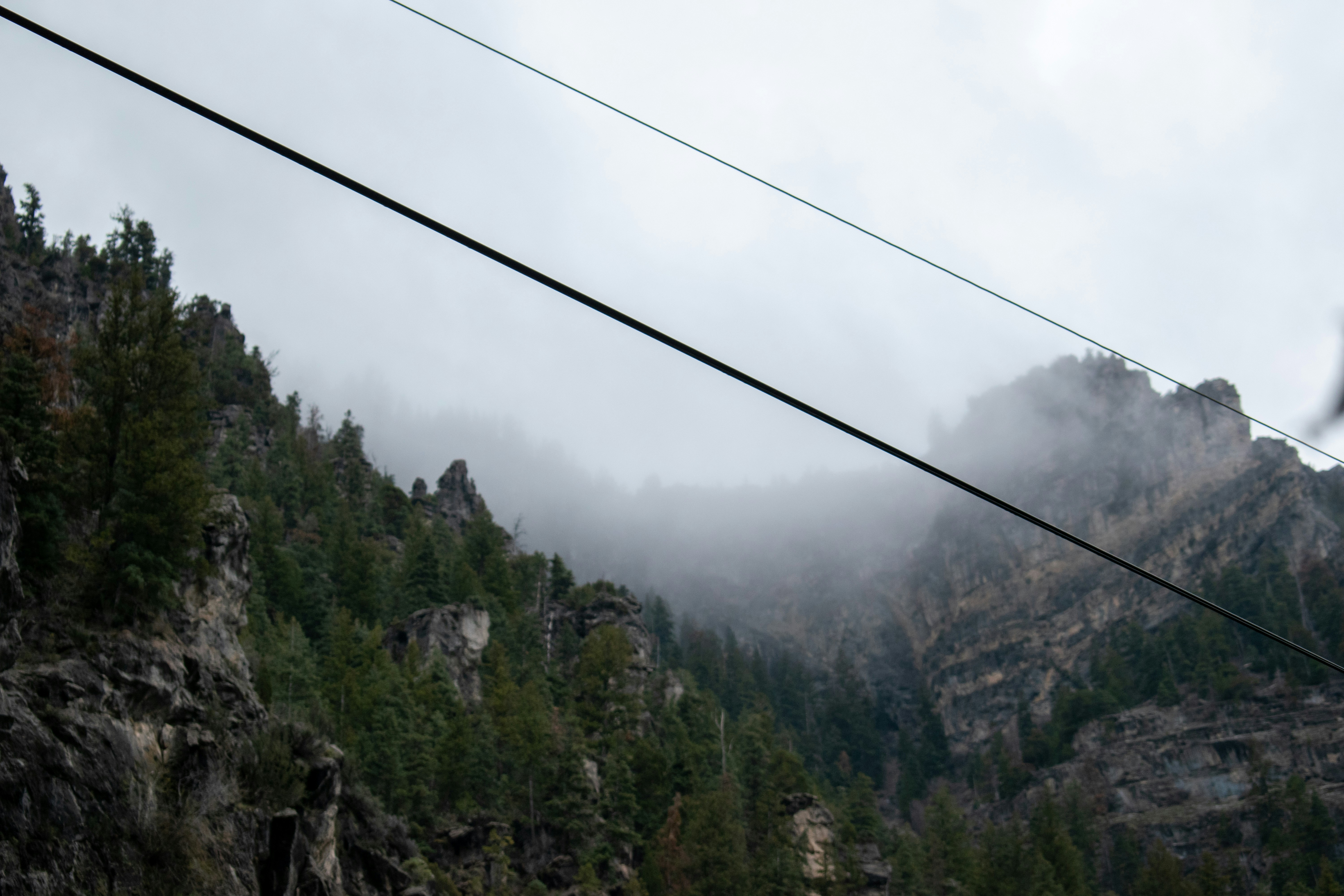 Mist-Wreathed Ridge Framed by Crossing Cables