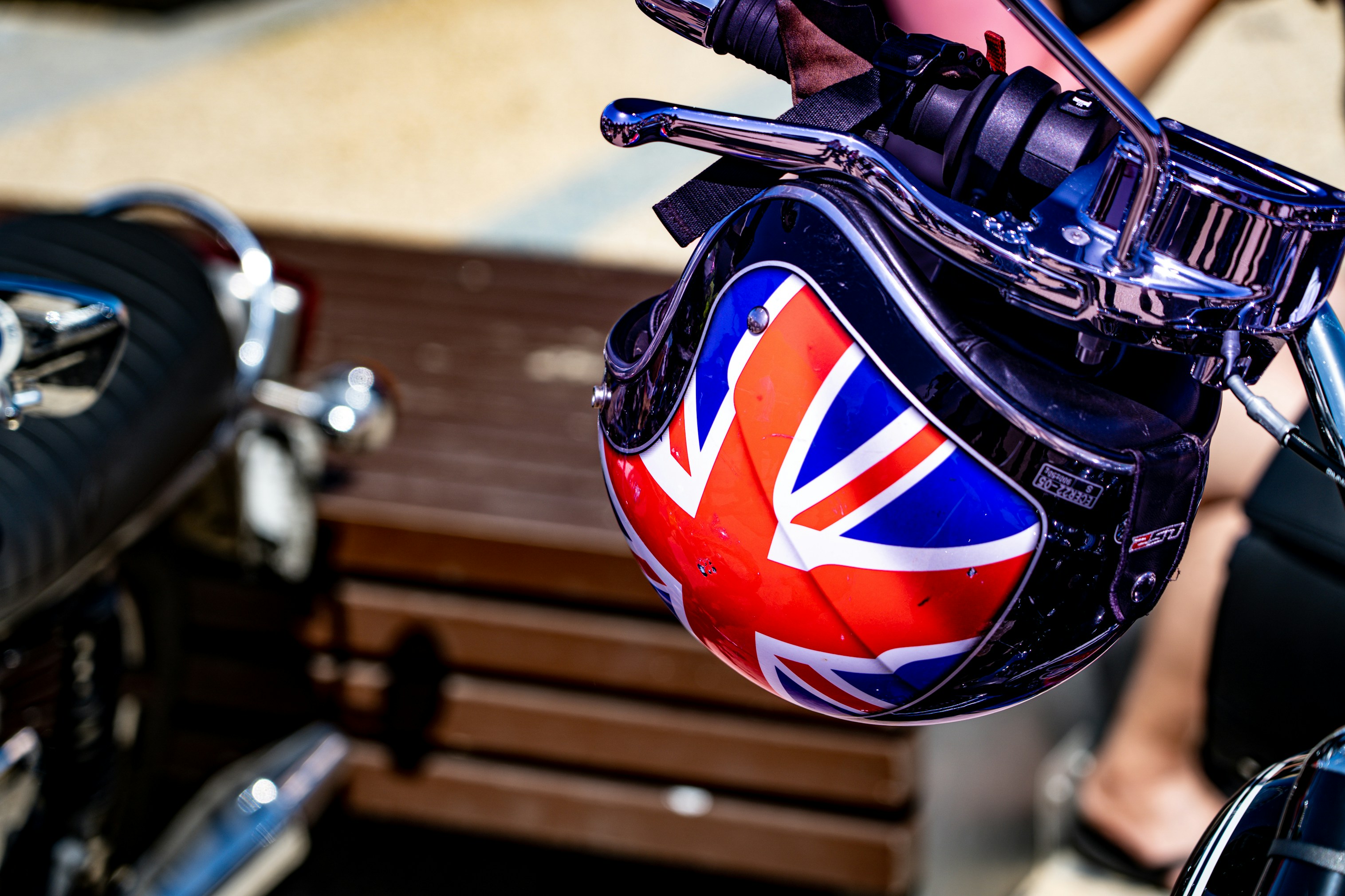 A Union Jack coloured motorbike helmet. | a helmet on the back of a motorcycle