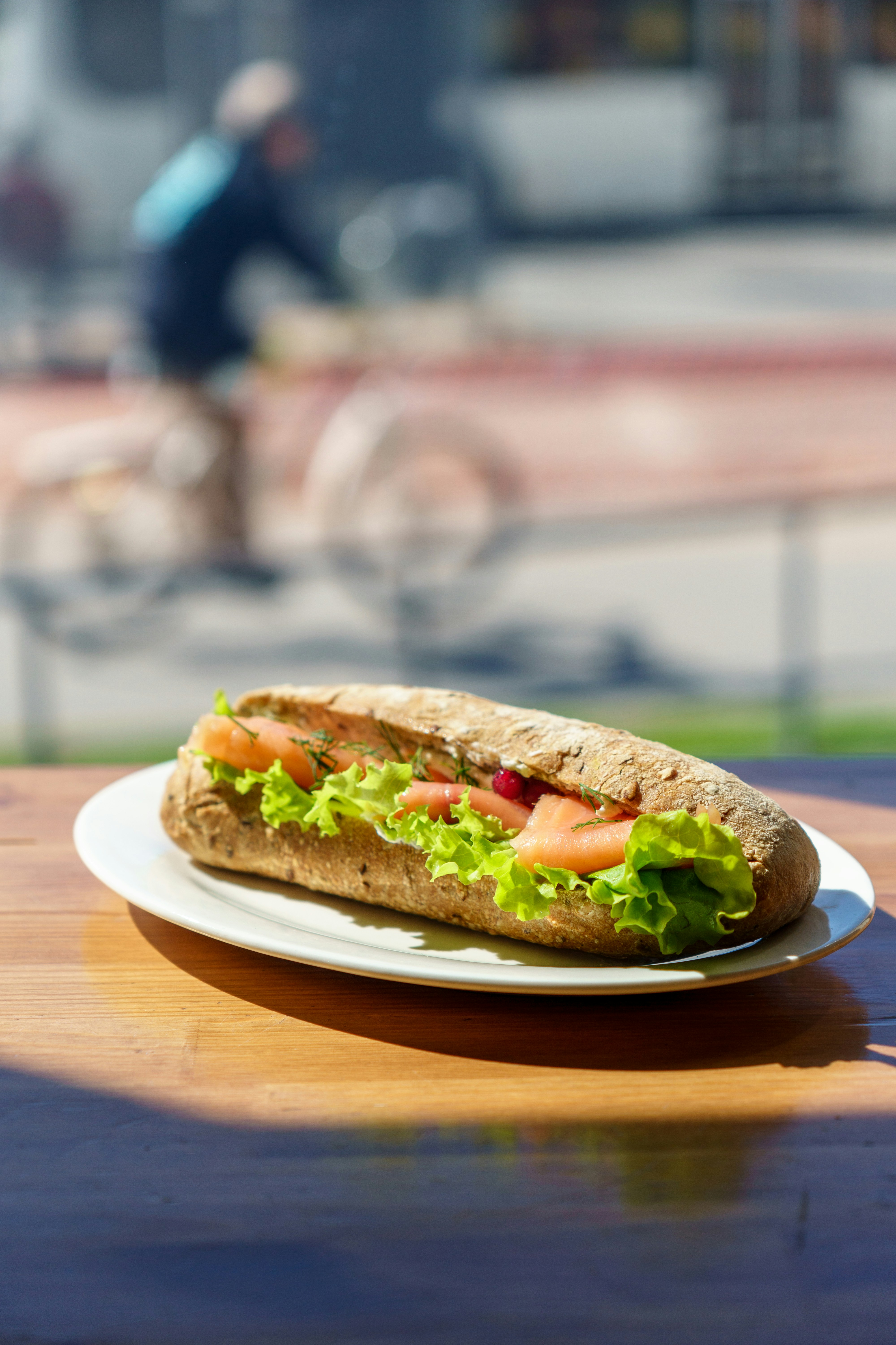 Sunlit Sandwich at the Forefront: A Crisp Bite Amid Urban Blur