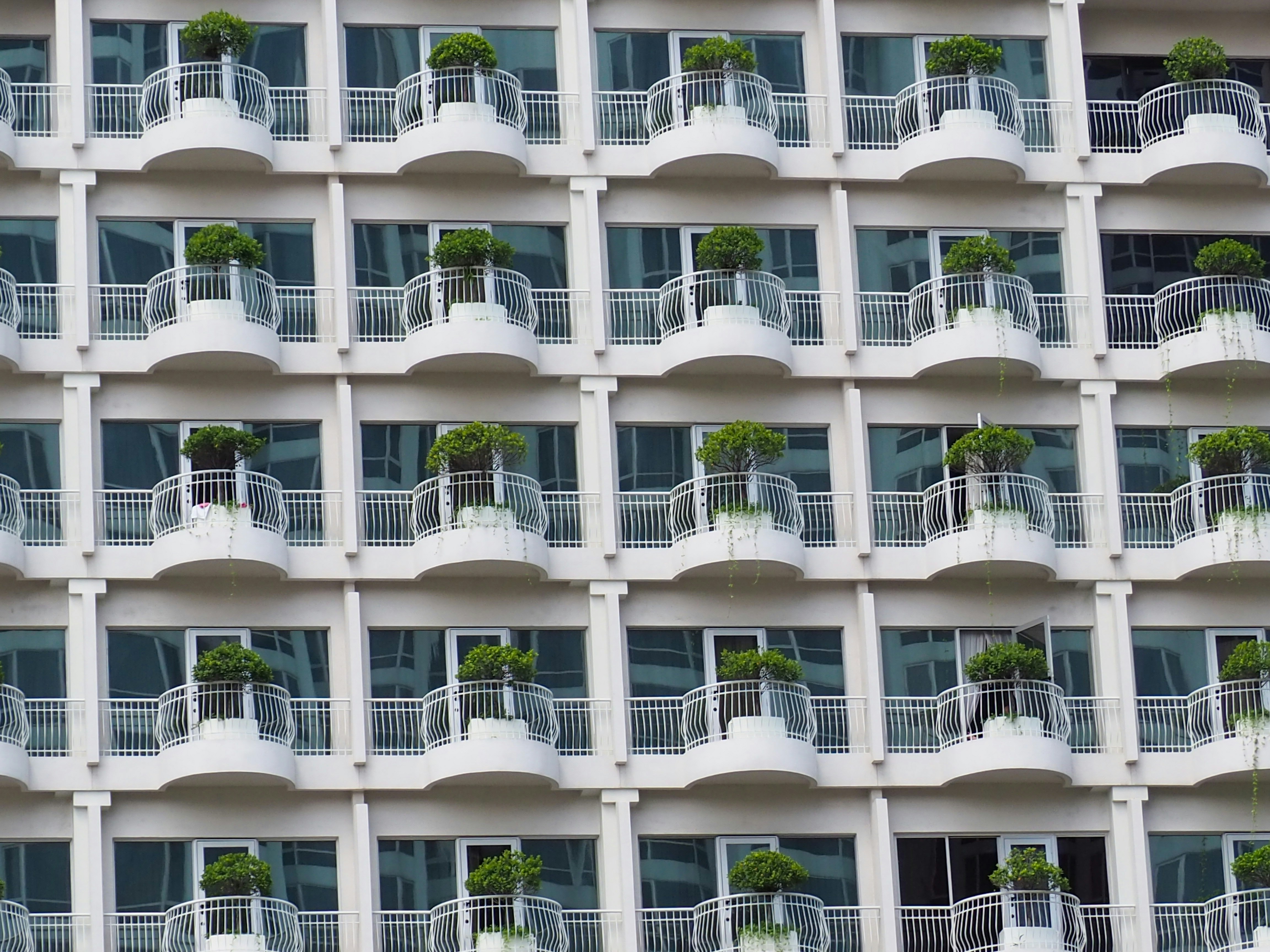 Foto Un edificio con balcones y plantas en los balcones – Imagen Gris gratis en Unsplash