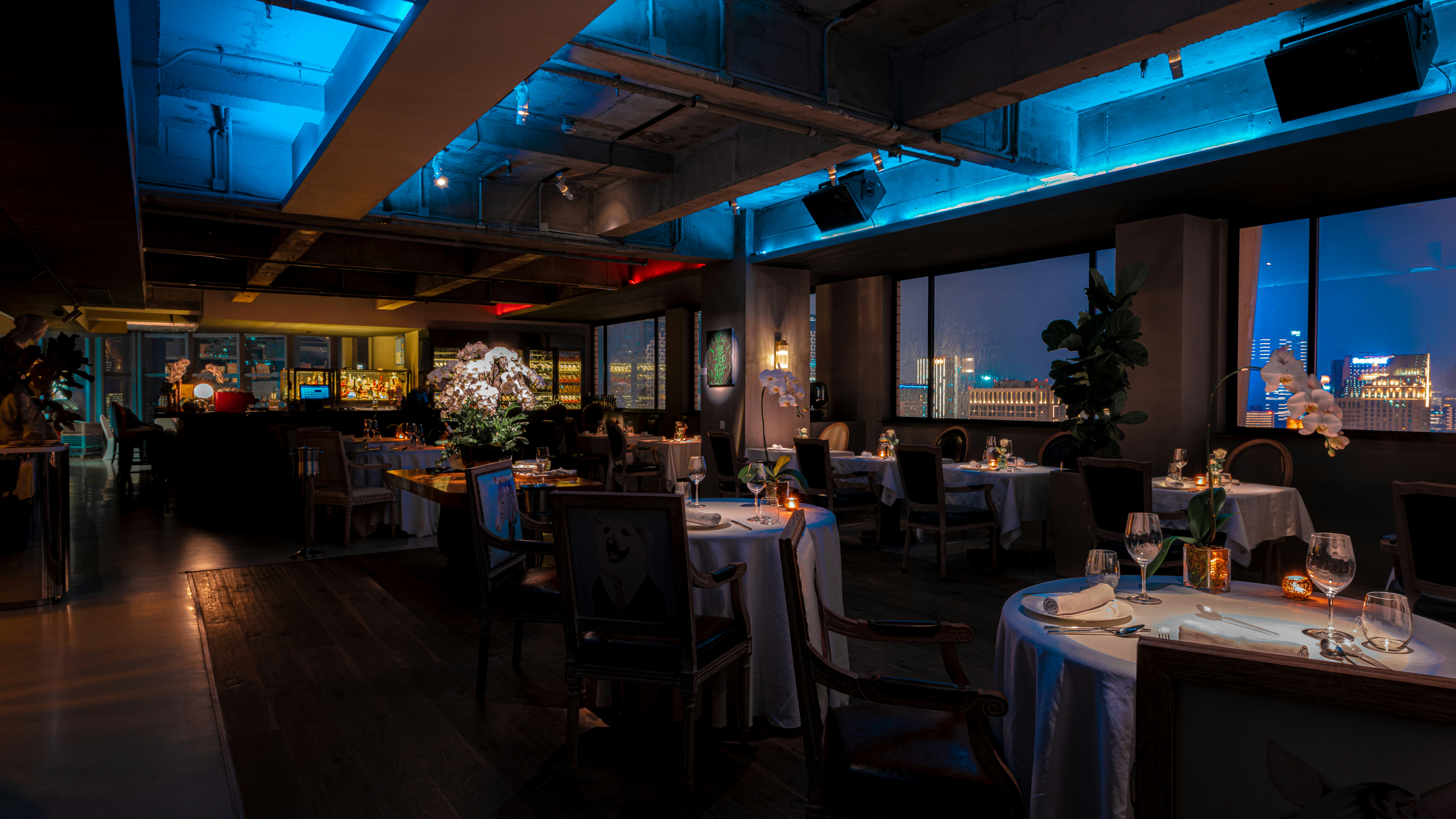 A dimly lit restaurant with a view of the city photo – Free Restaurants ...