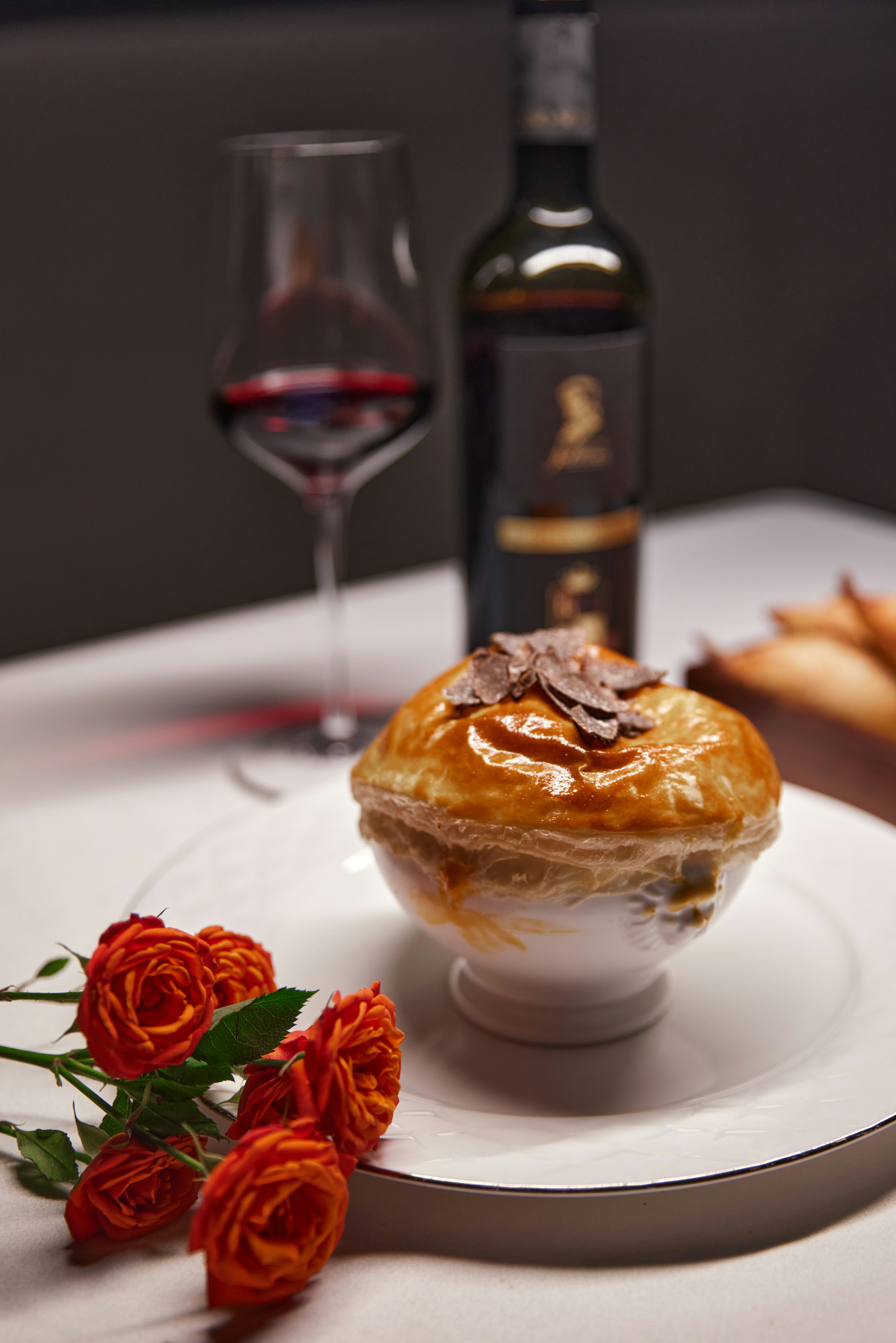 Gilded Souffle in Focus: Vanilla Glaze Roosts beside a Quiet Red