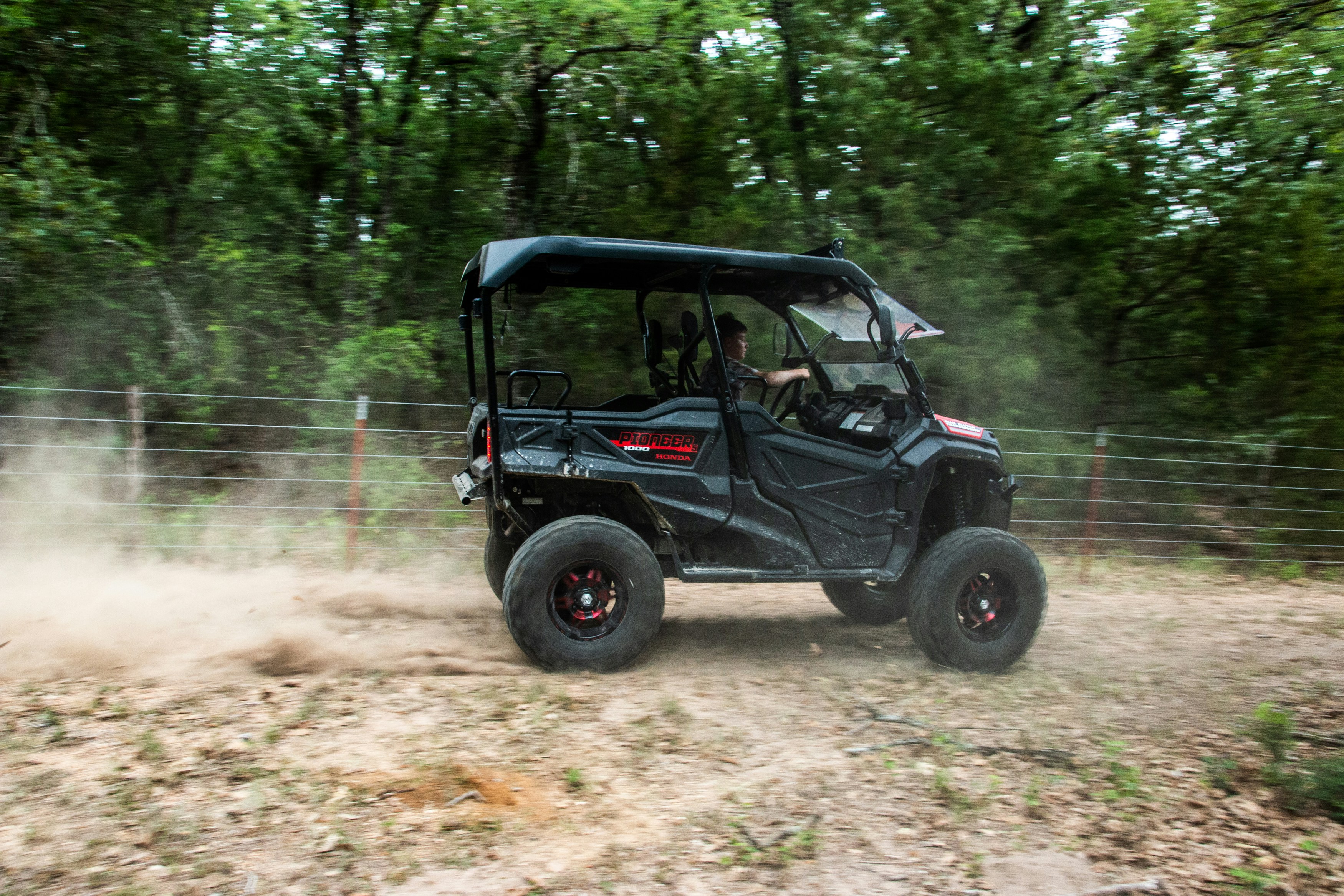 A man driving a black utv on a dirt road photo – Free Grey Image on ...