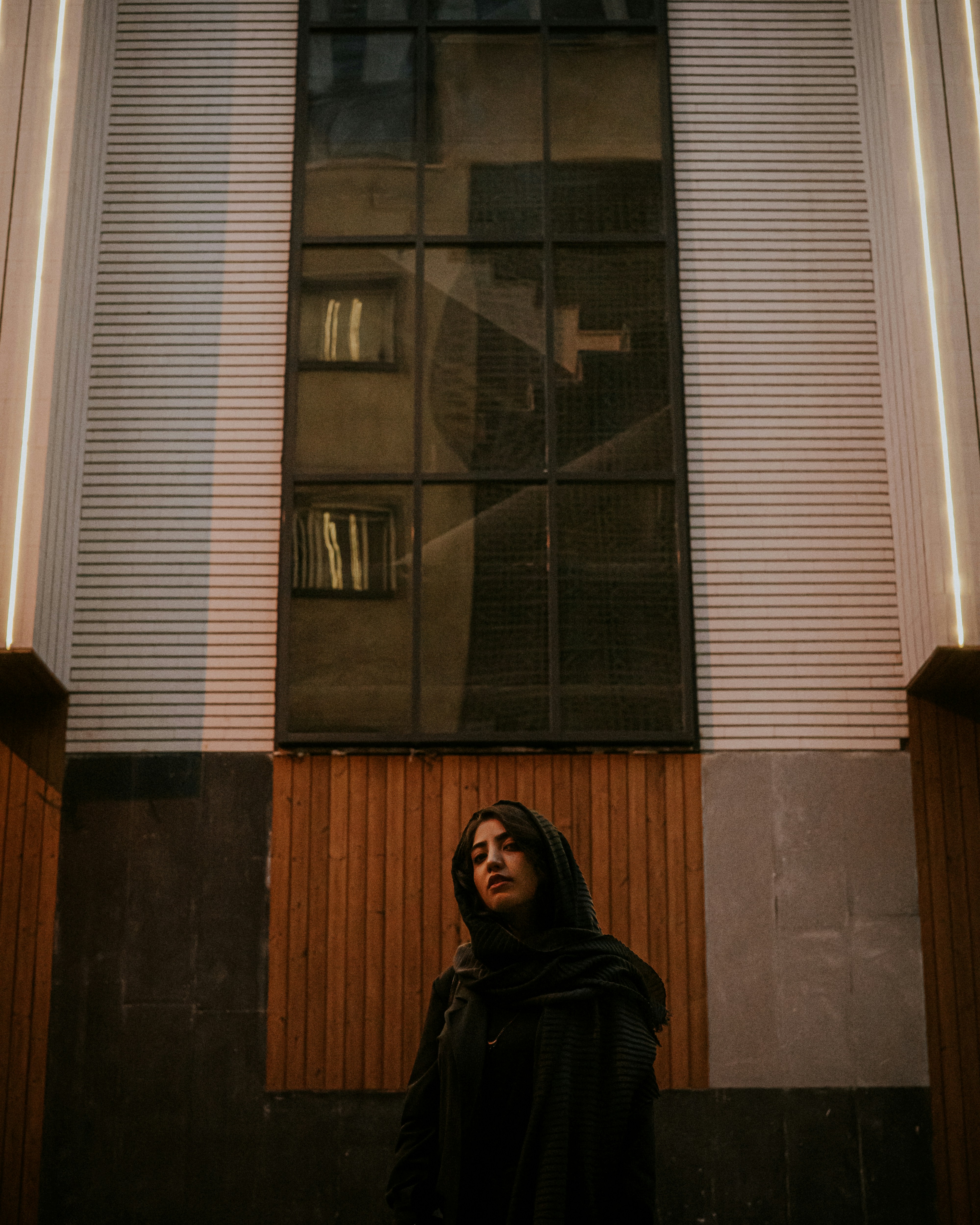 A woman standing in front of a tall building photo – Free Home decor ...