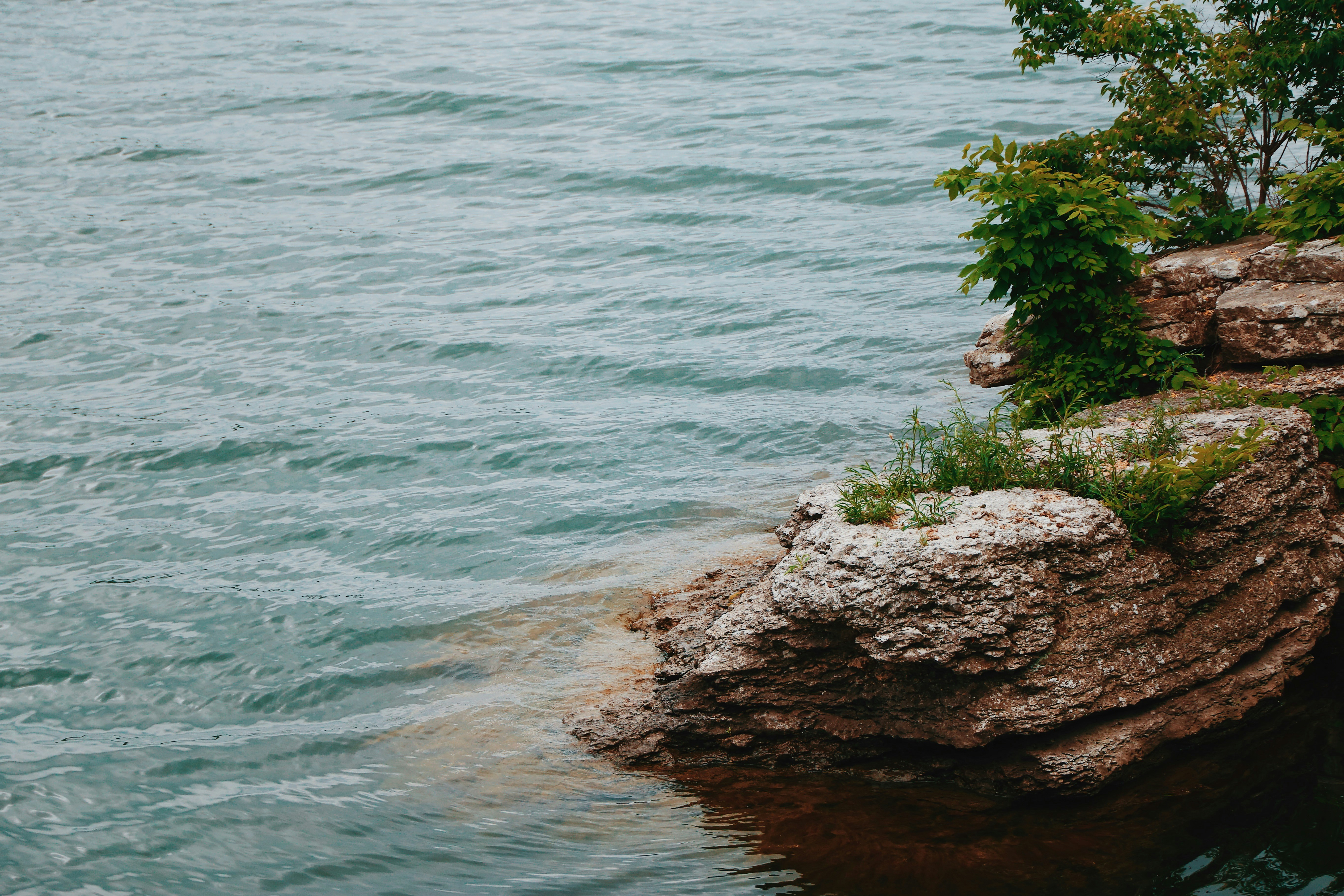 A rock outcropping in the middle of a body of water photo – Free Grey ...