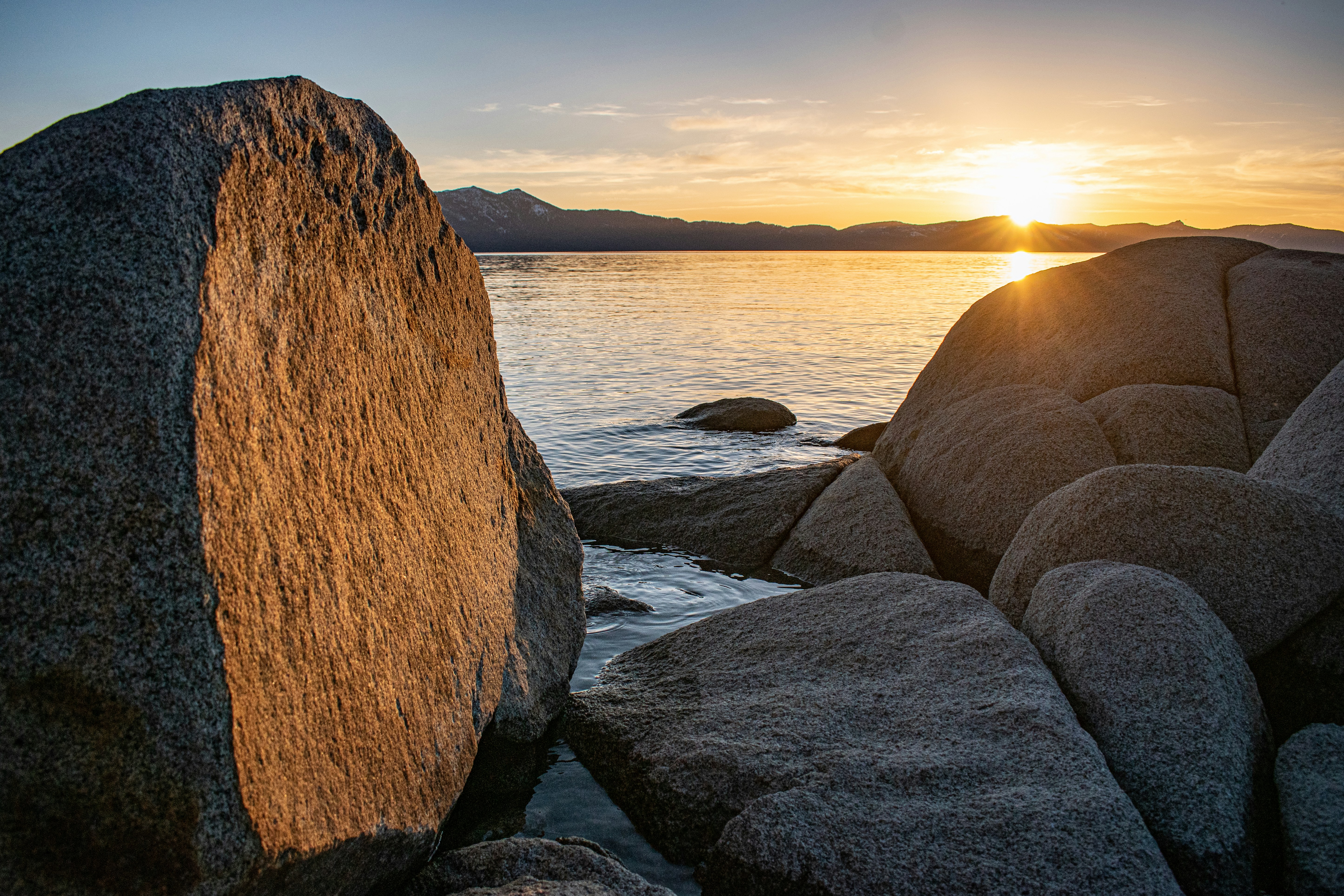 A large rock sitting next to a body of water photo – Free Brown Image ...