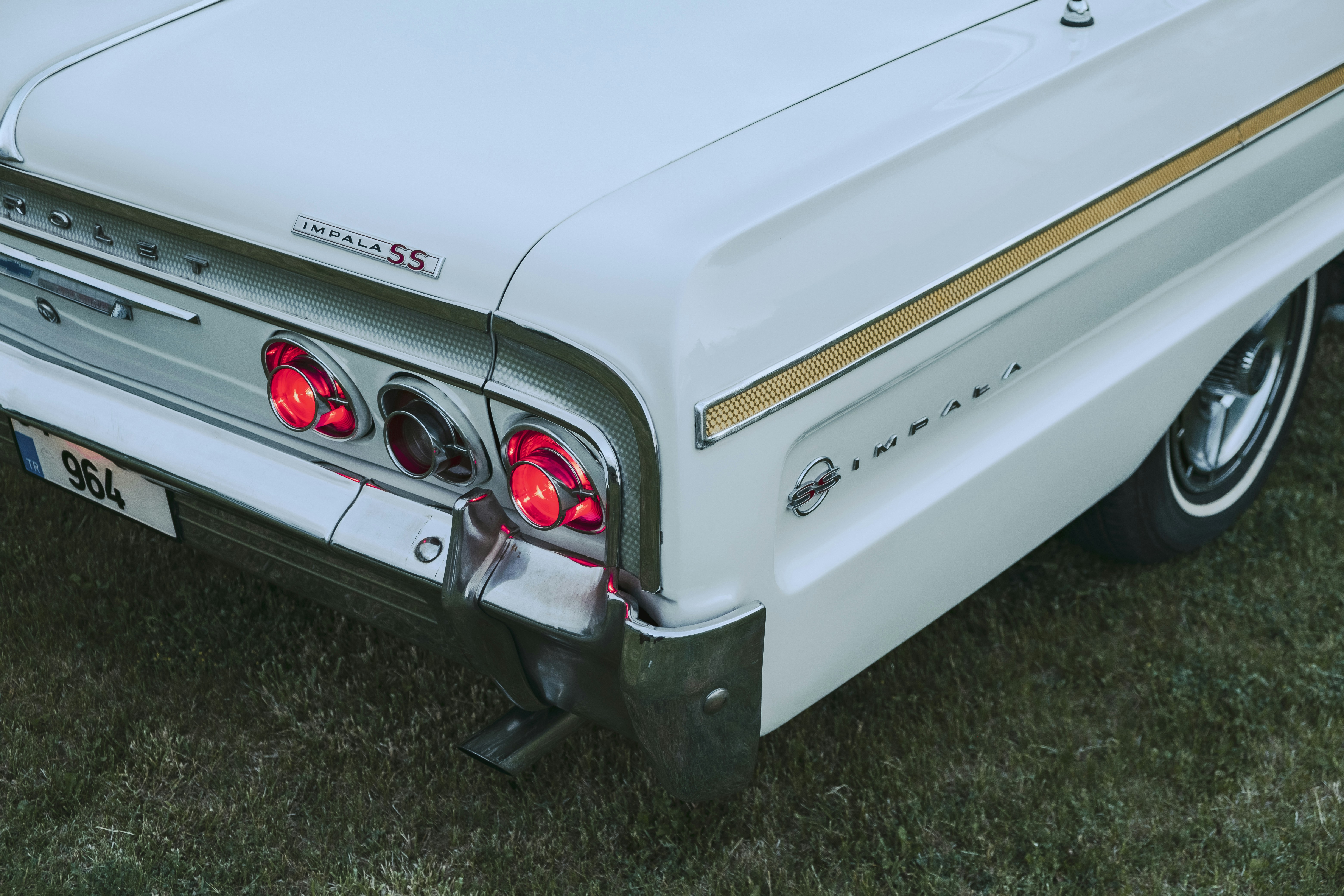 Rear Corner Reverie: 1963 Impala SS's chrome glow on grass