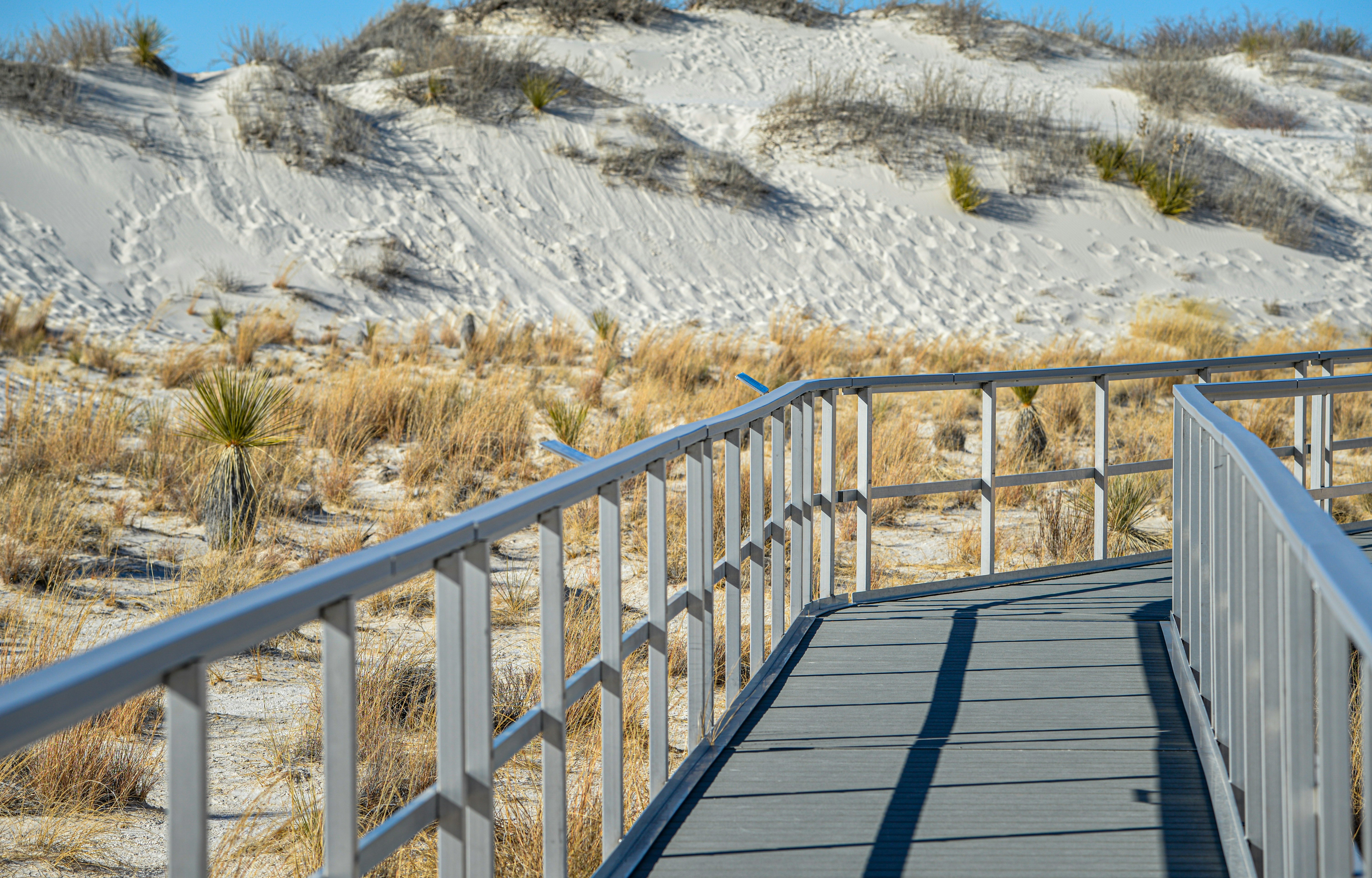 a wooden walkway leading to a sandy beach