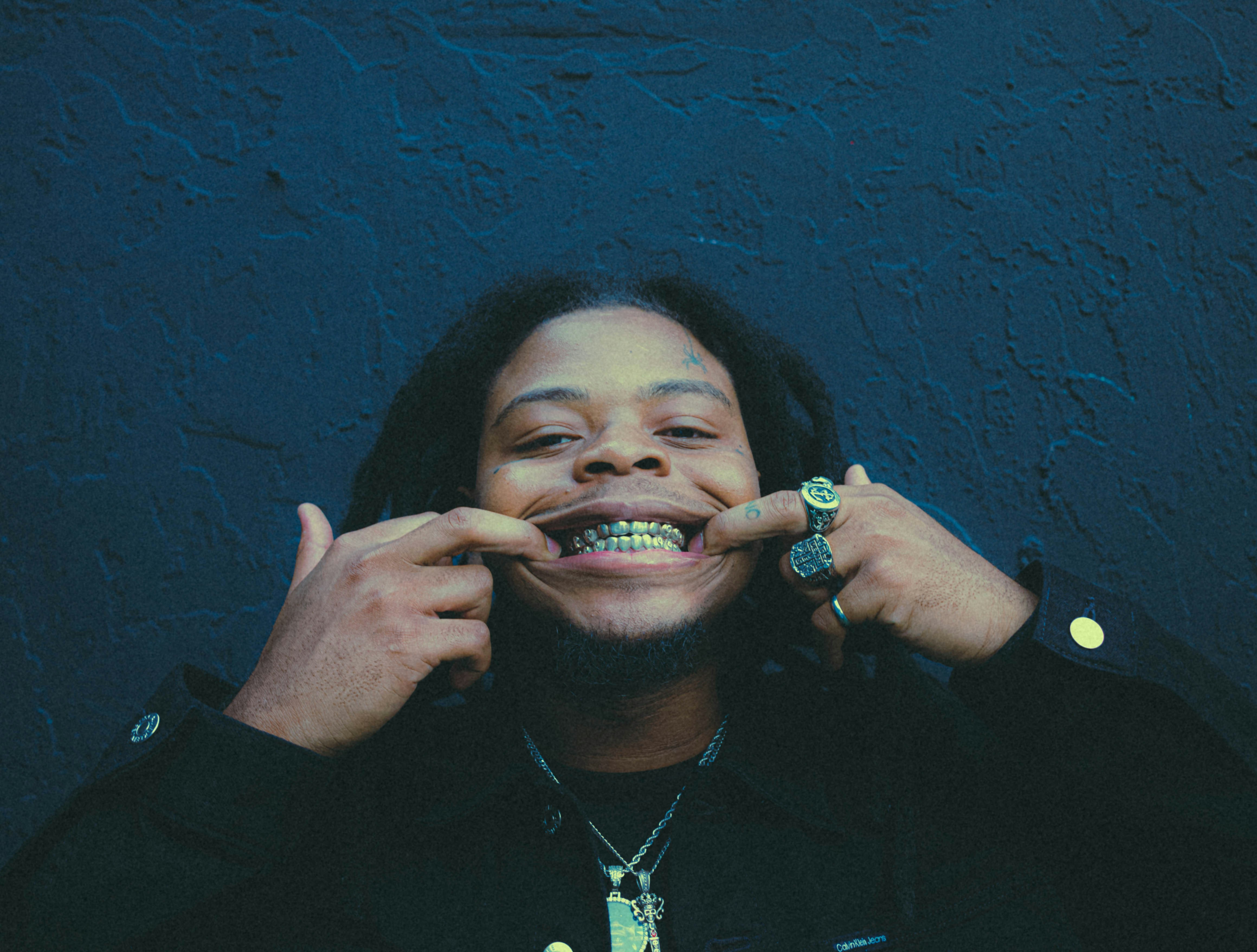 Grin-centered: Chains and chrome in a blue-tinted portrait