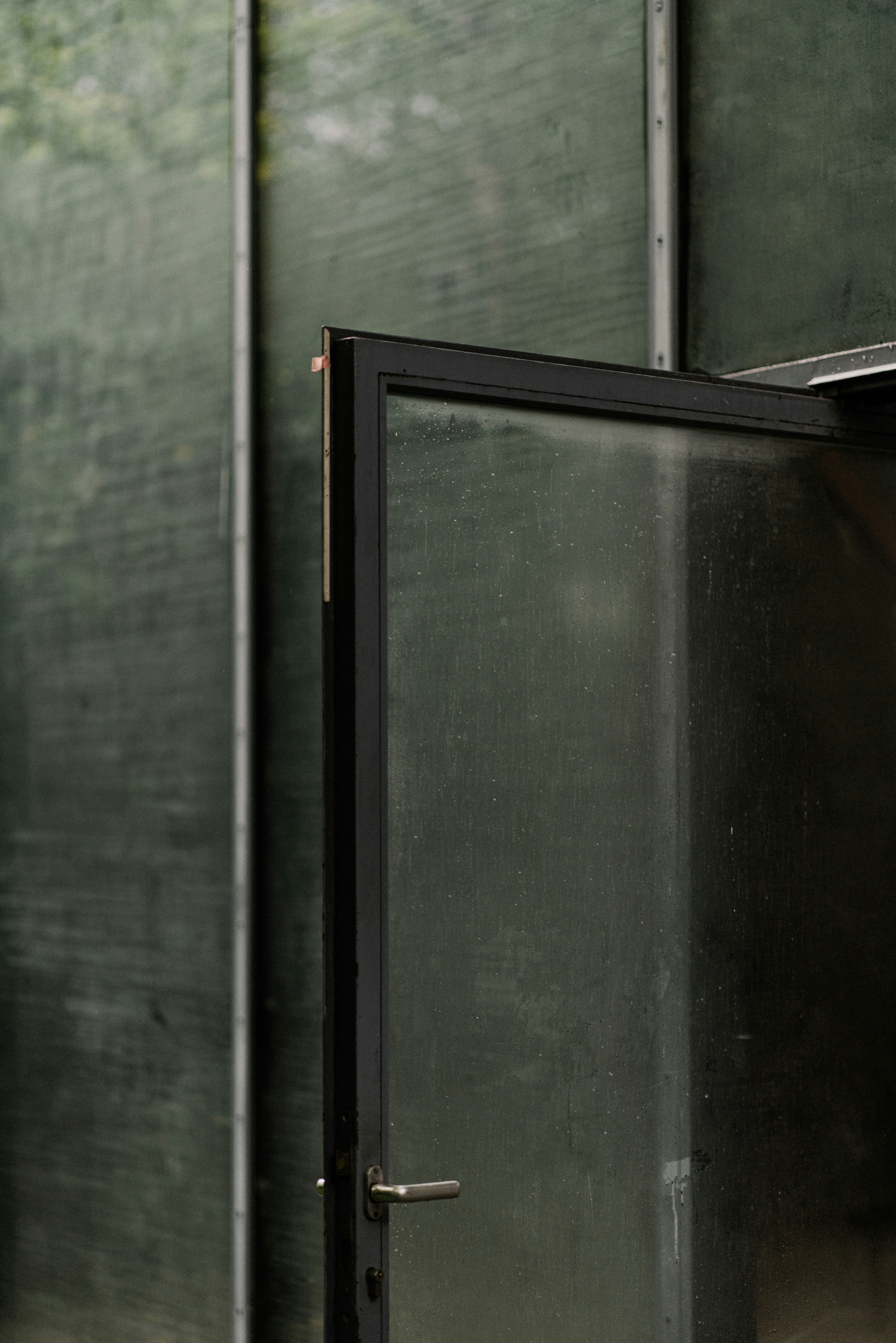 Threshold in Steel and Glass: Dim-Green Corridor Doorway
