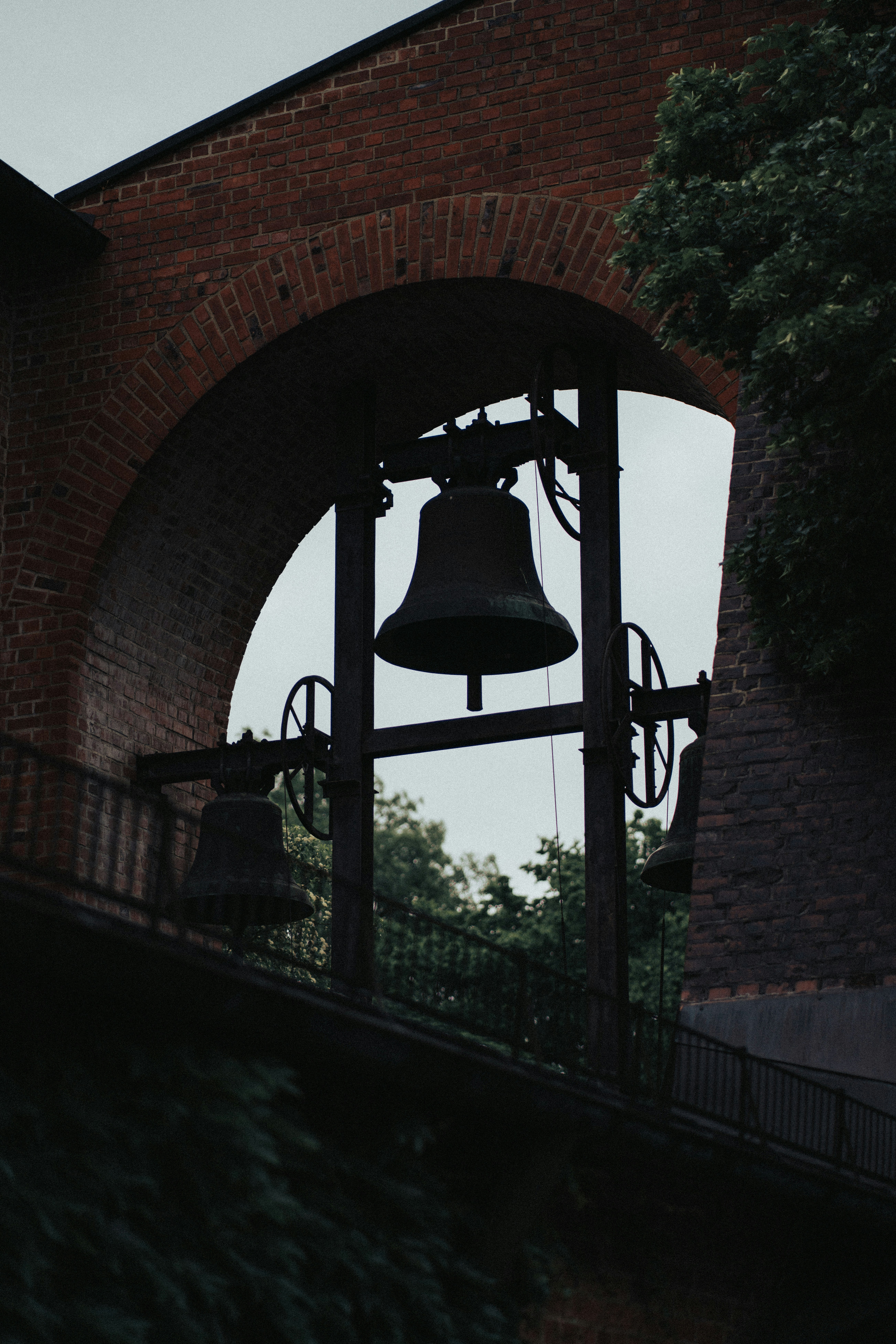 a bell is hanging from a brick wall