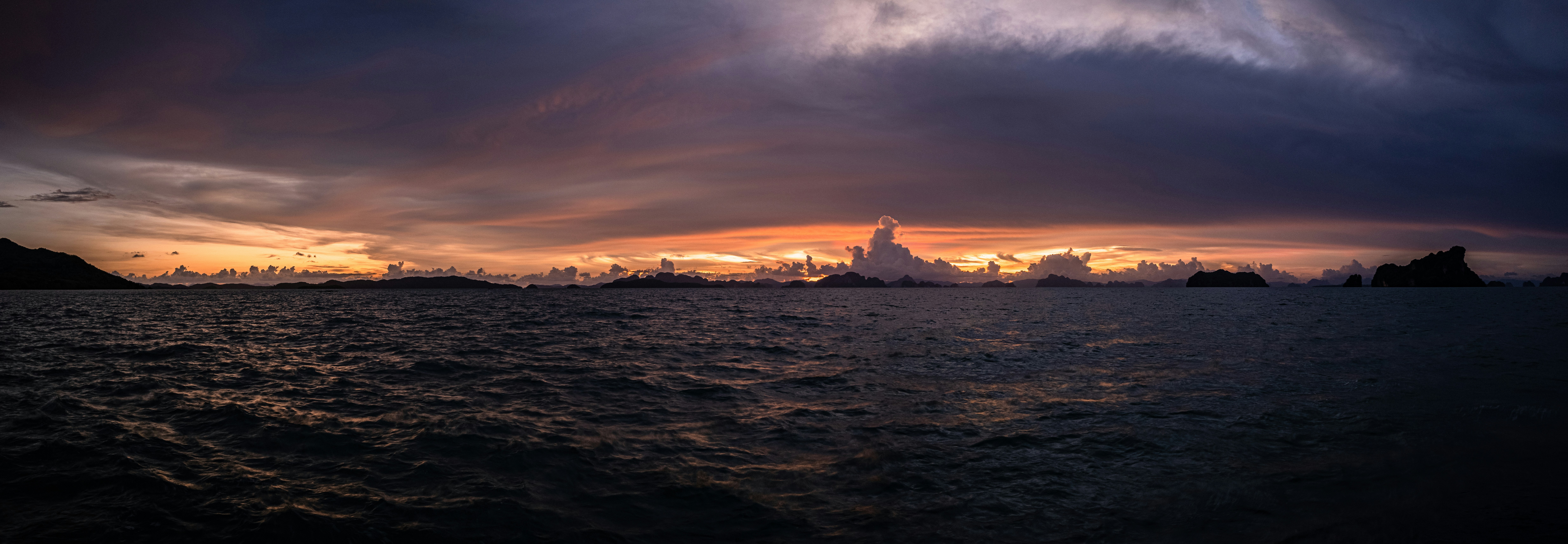 Foto El sol se está poniendo sobre un cuerpo de agua – Imagen Phang Nga ...