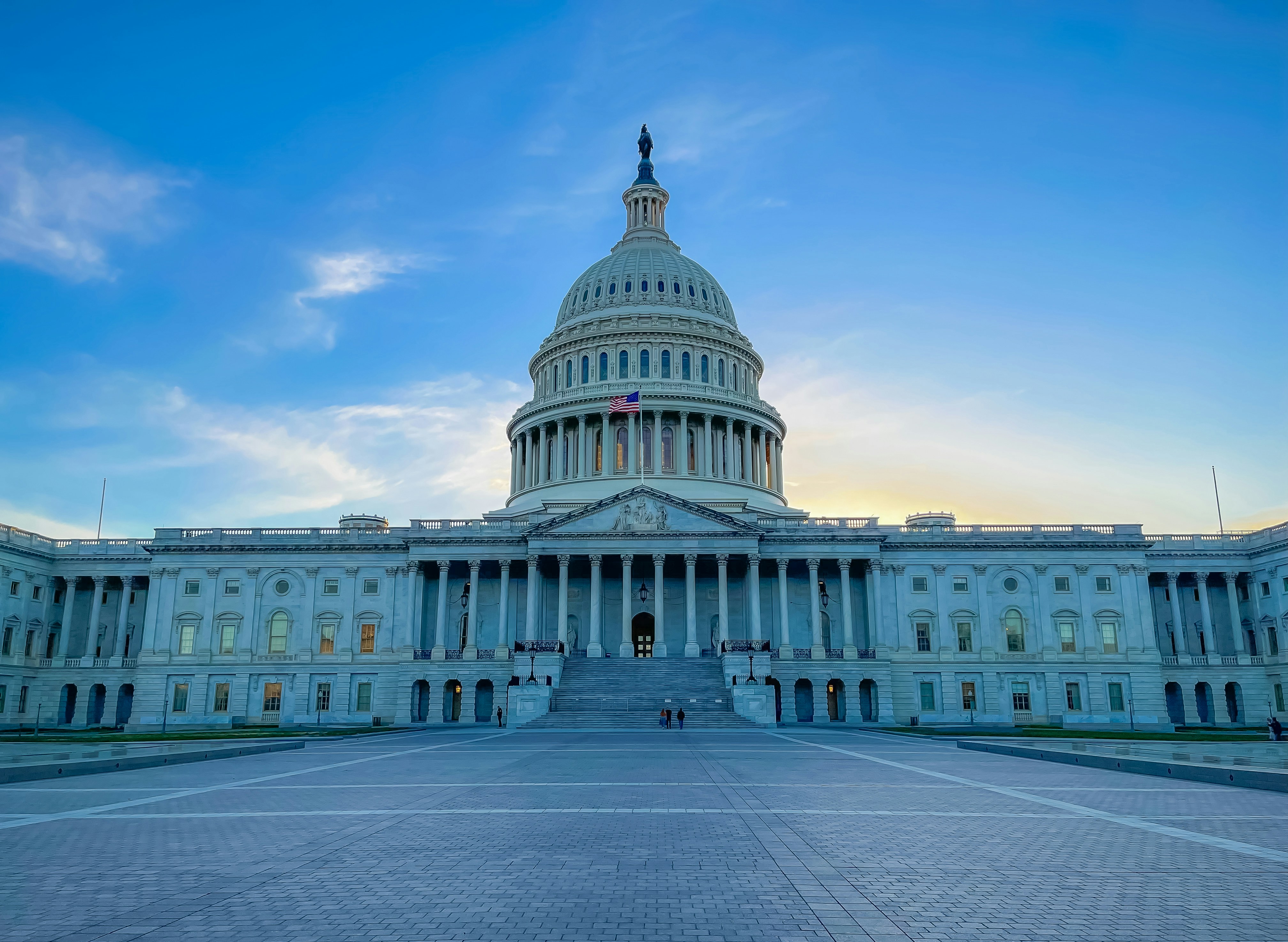 The United States Capitol building stands majestically against a twilight sky, showcasing its architectural grandeur and historical significance.