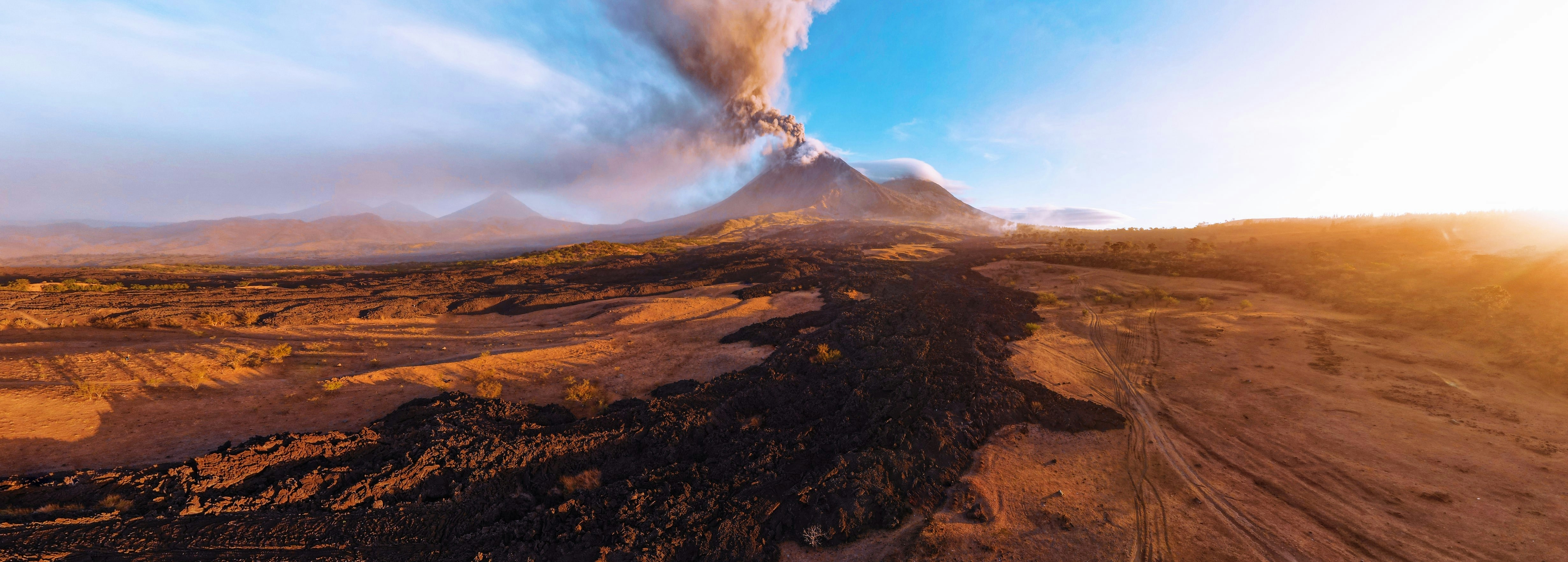 An aerial view of a volcano spewing smoke photo – Free Mountain Image ...