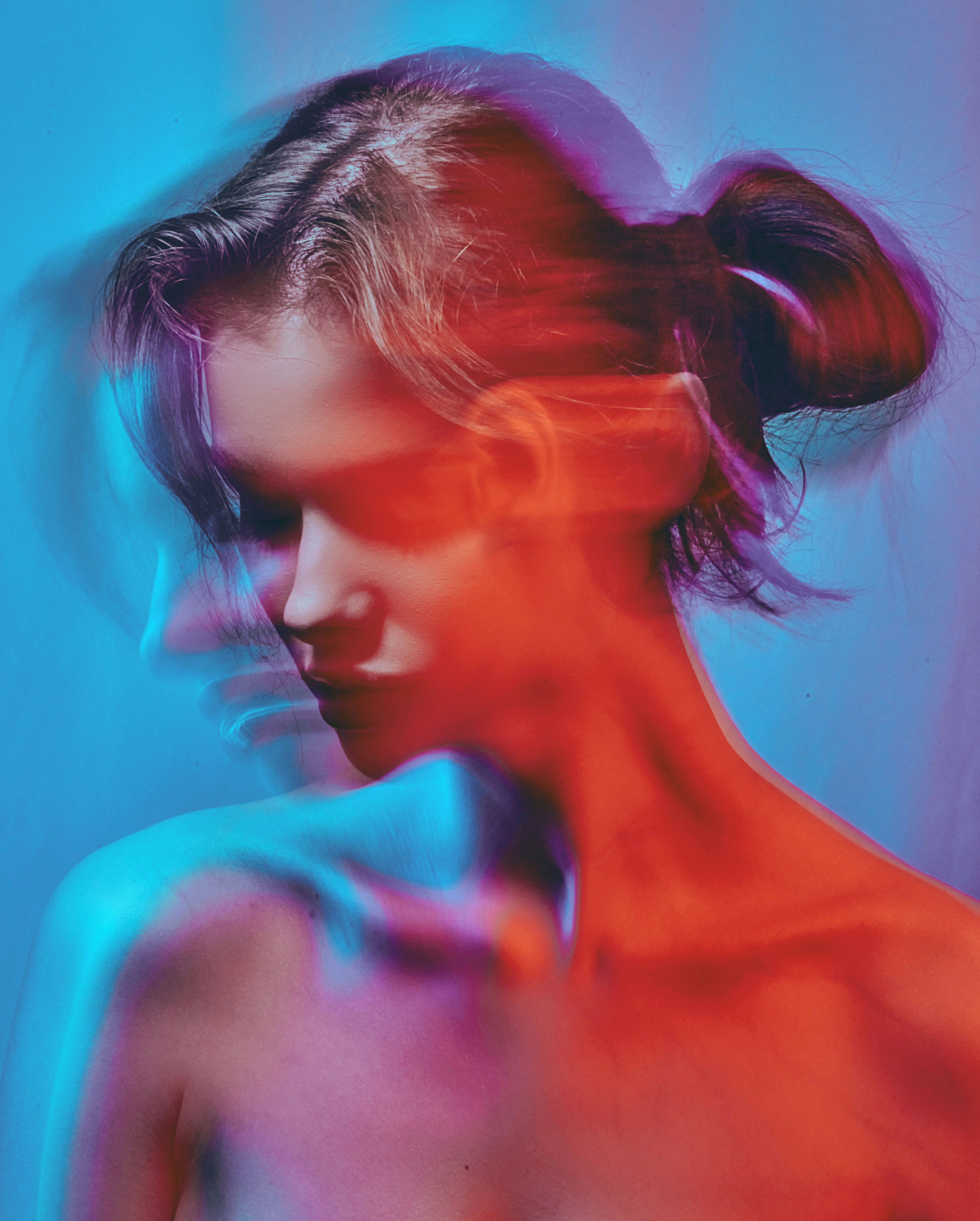 Abstract representation of a woman's profile, featuring vibrant blue and red hues that create a sense of motion and depth.