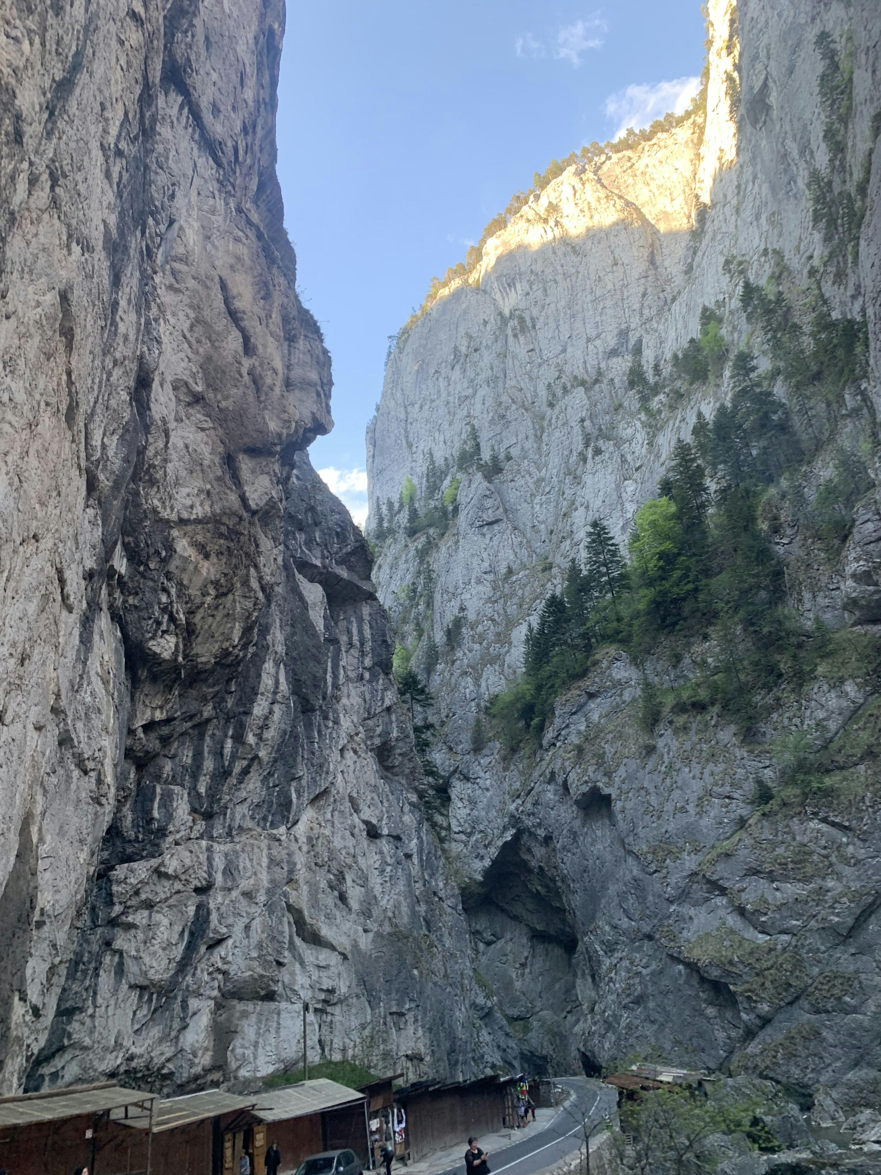 Cheile Bicazului. Road crossing through two walls of stone | a group of people standing on the side of a mountain