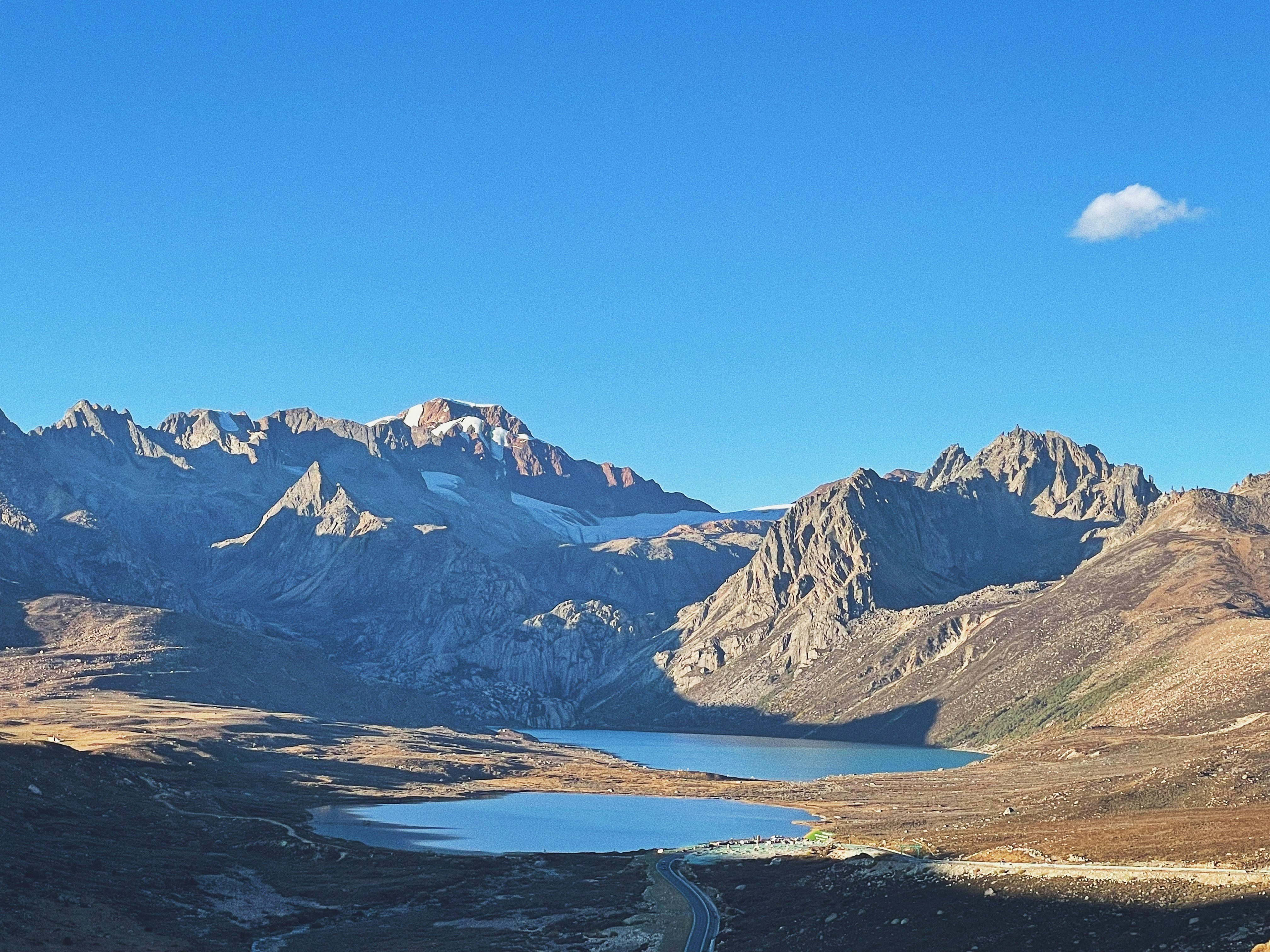 A view of a mountain range with a lake in the foreground photo – Free ...