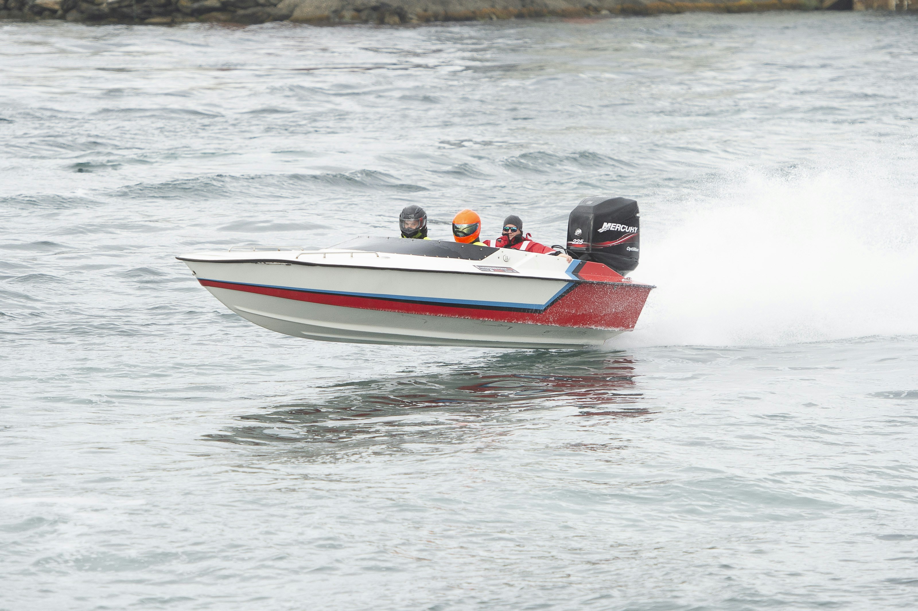 A speed boat with four people in it speeds through the water photo ...