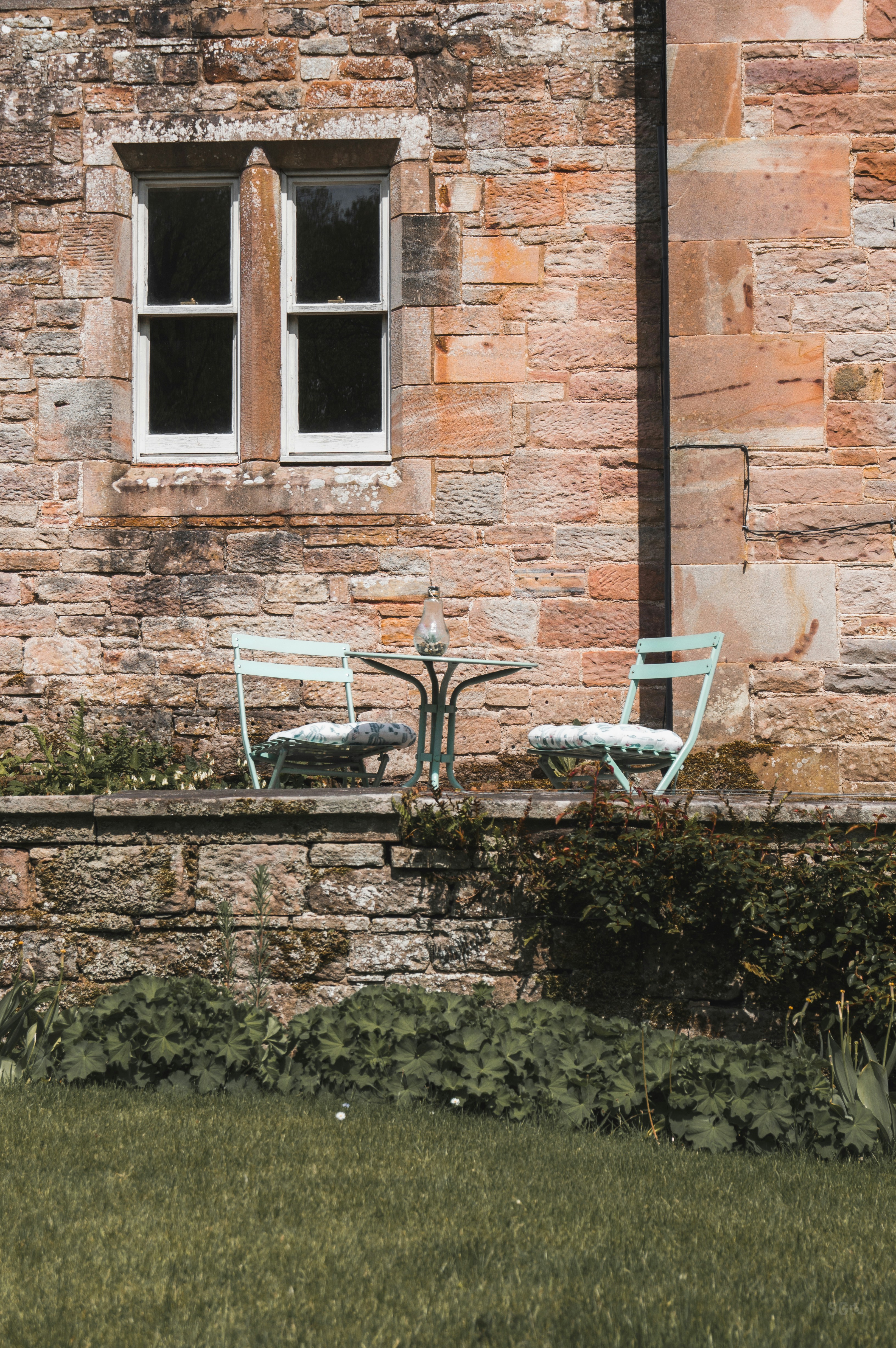 Sunlit Stone Terrace: Mint Chairs Framing a Quiet Table