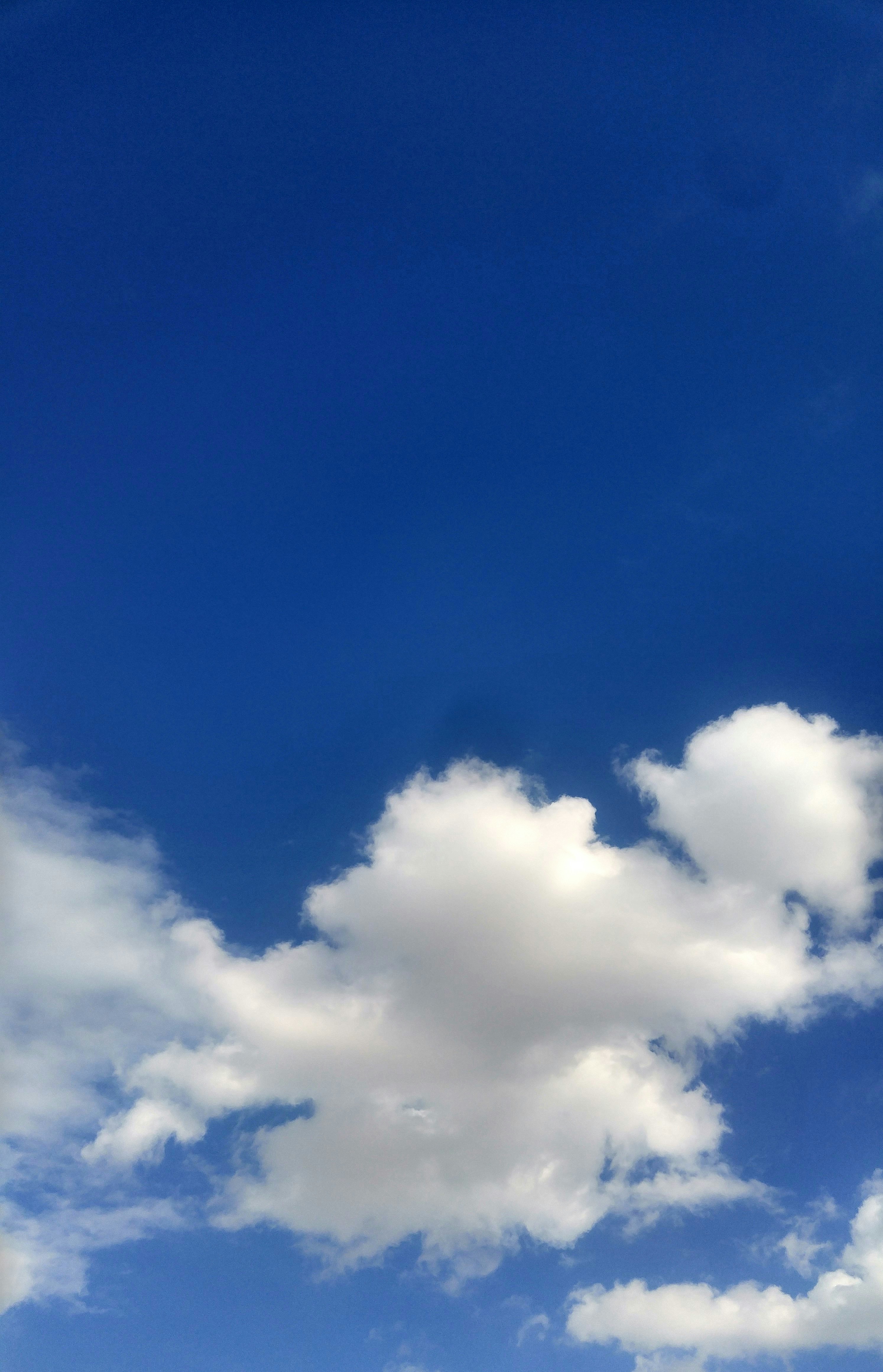 Fluffy white clouds drifting across a deep blue sky, creating a serene atmosphere.