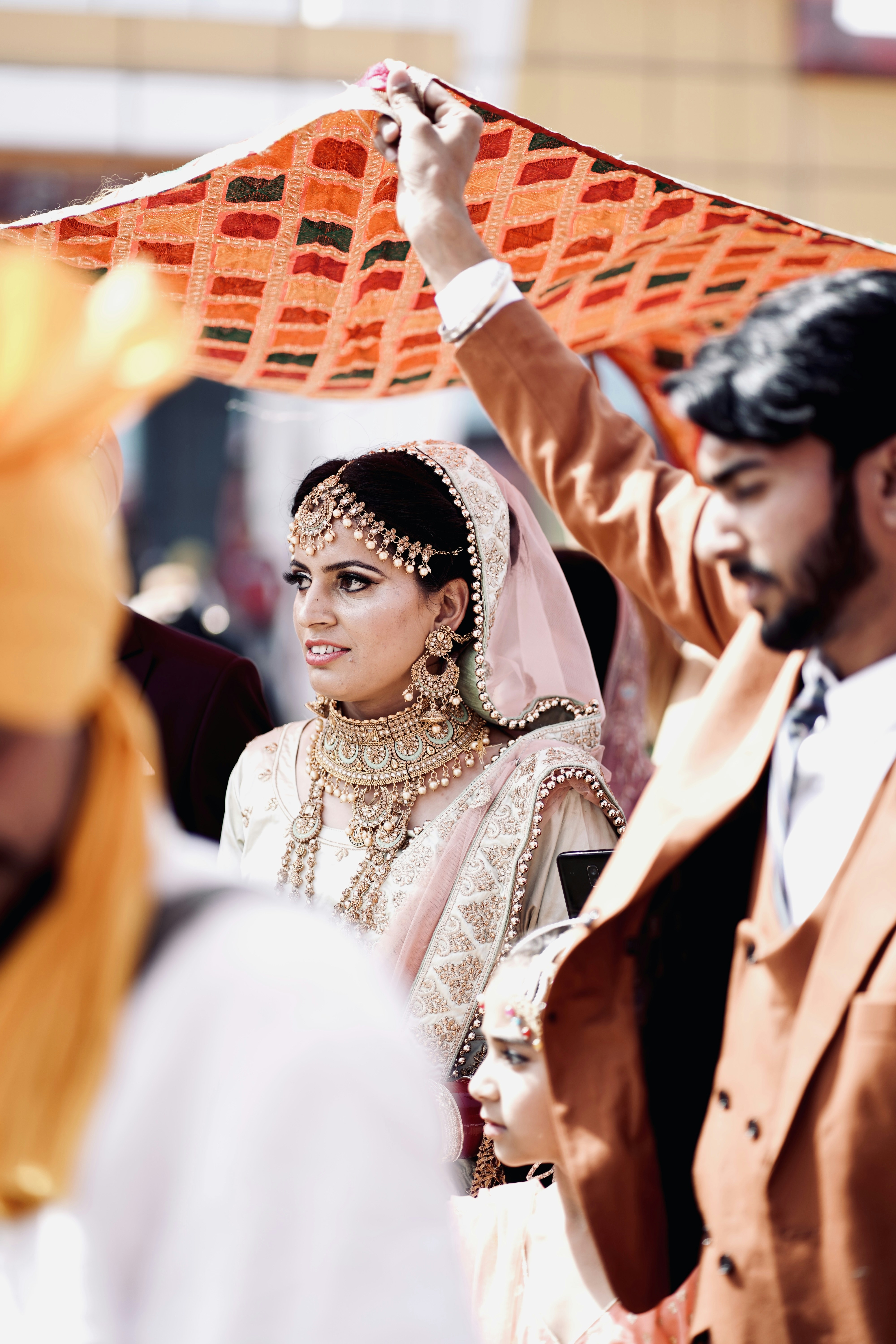 A woman in a bridal outfit holding a shawl over her head photo – Free ...