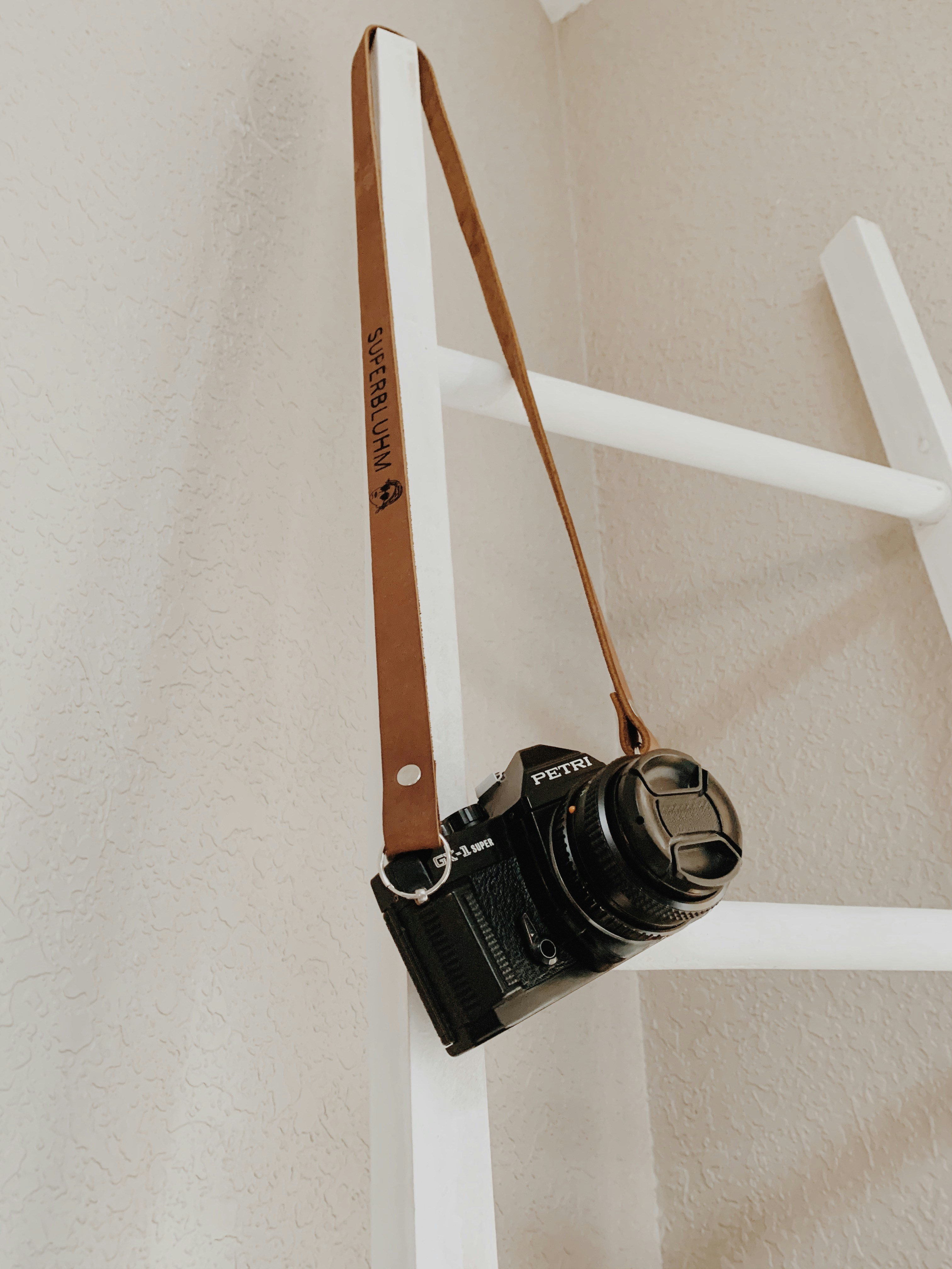 A camera hanging on a ladder in a room photo – Free Brown Image on Unsplash