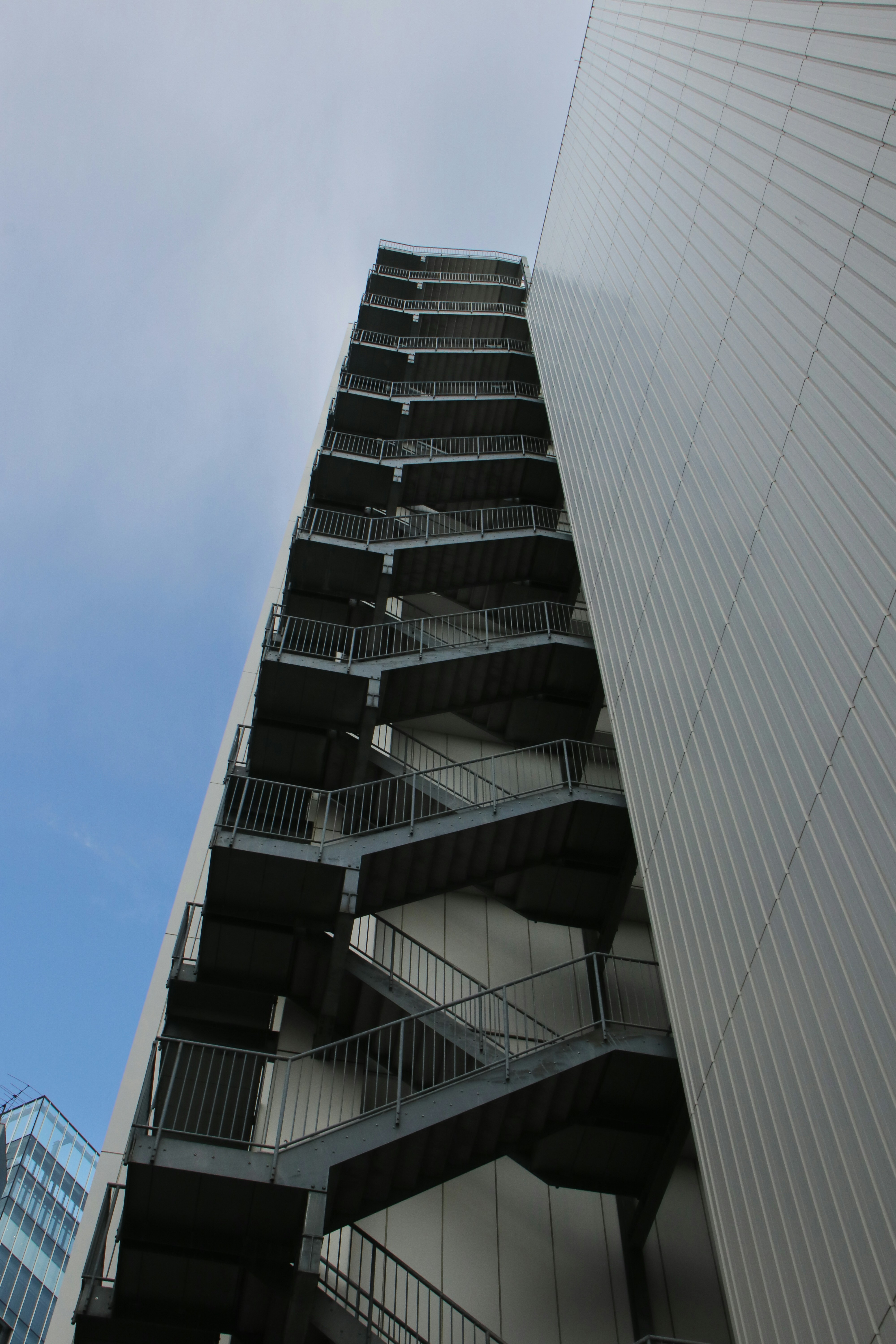 Zigzag Fire Escape Ascending a Glass-Clad Tower
