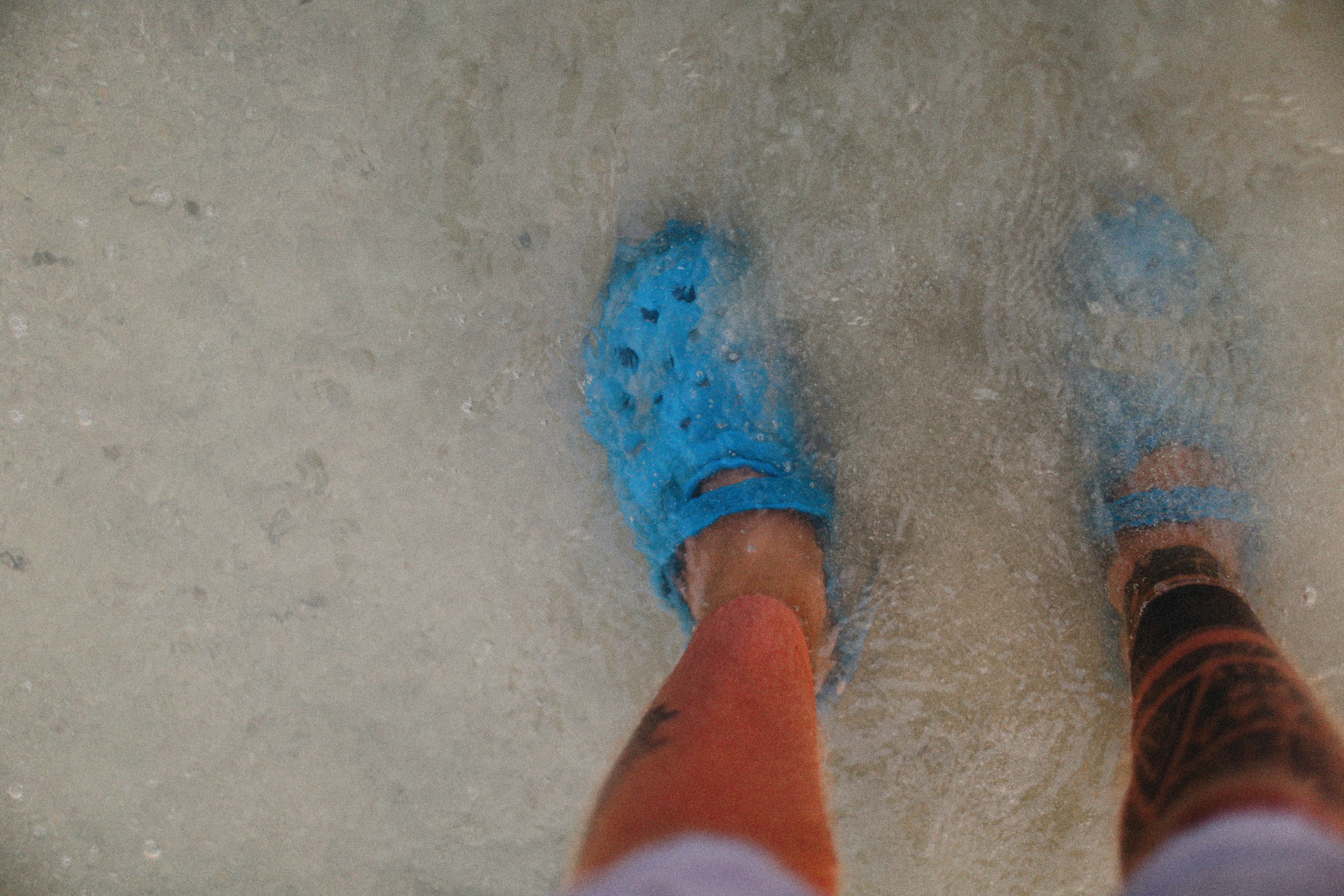 a person with blue shoes standing in the snow