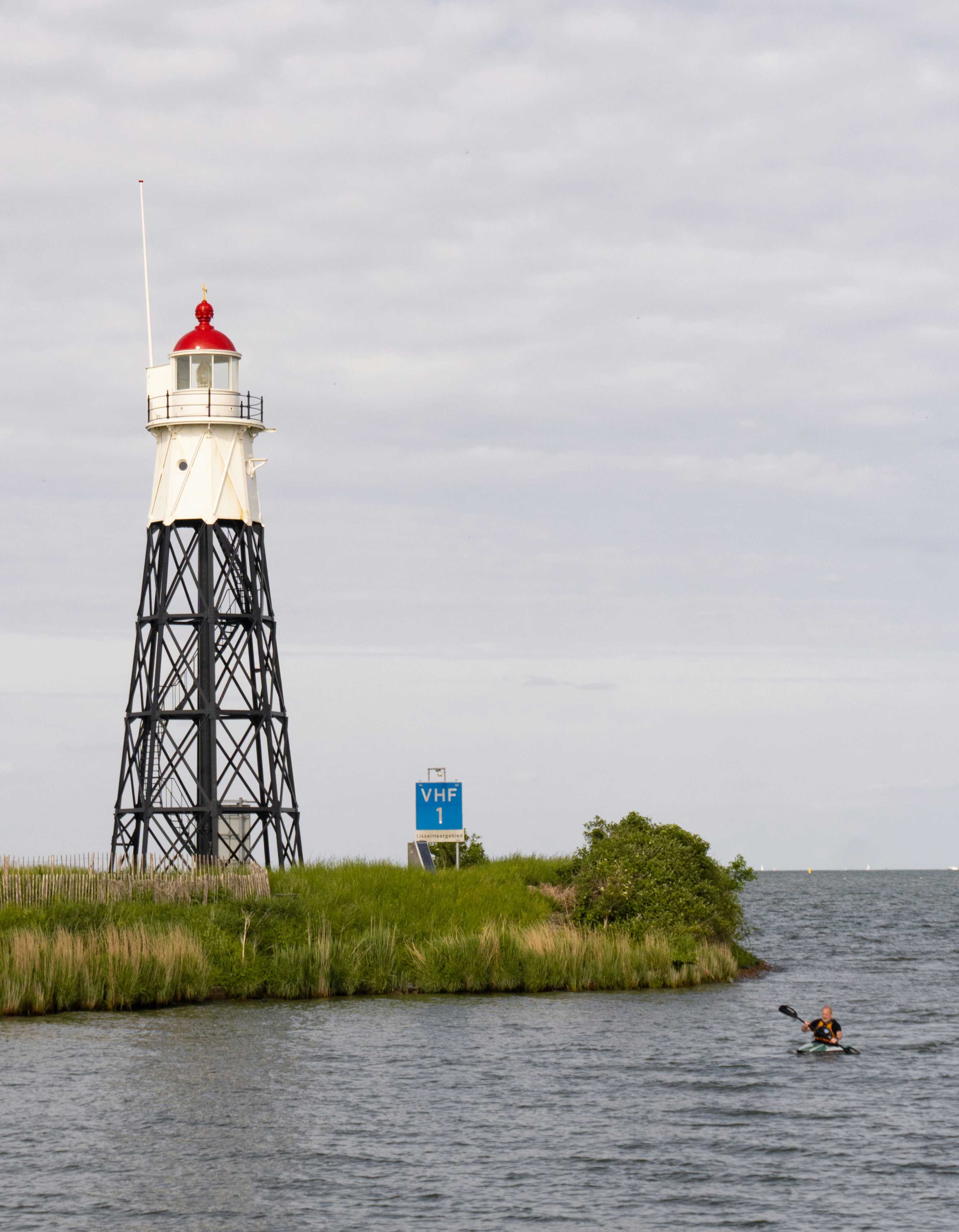 Beacon on the Edge: A Lighthouse Standing Guard Over Quiet Waters