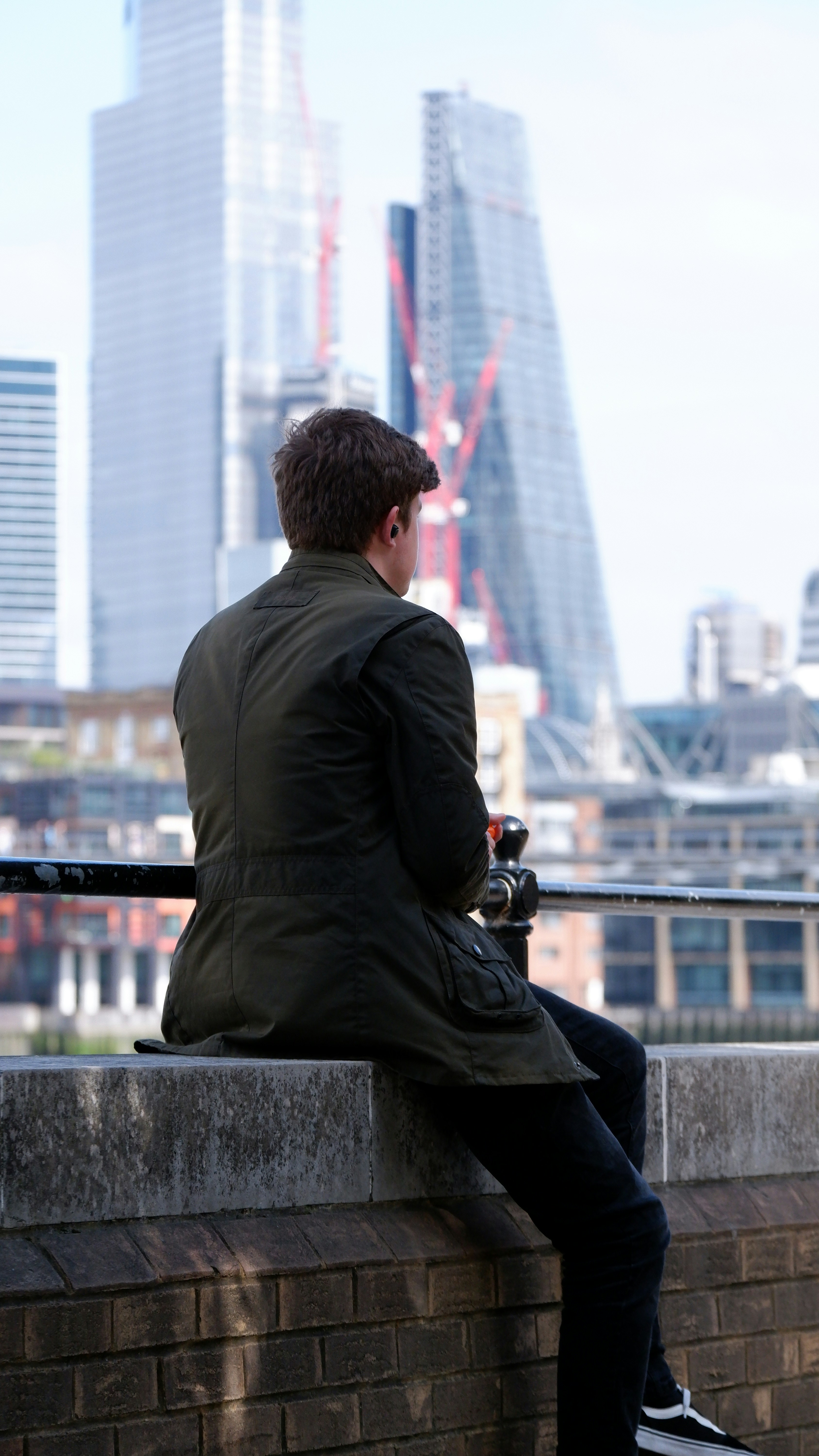 Man sitting on a wall overlooking the River Thames.