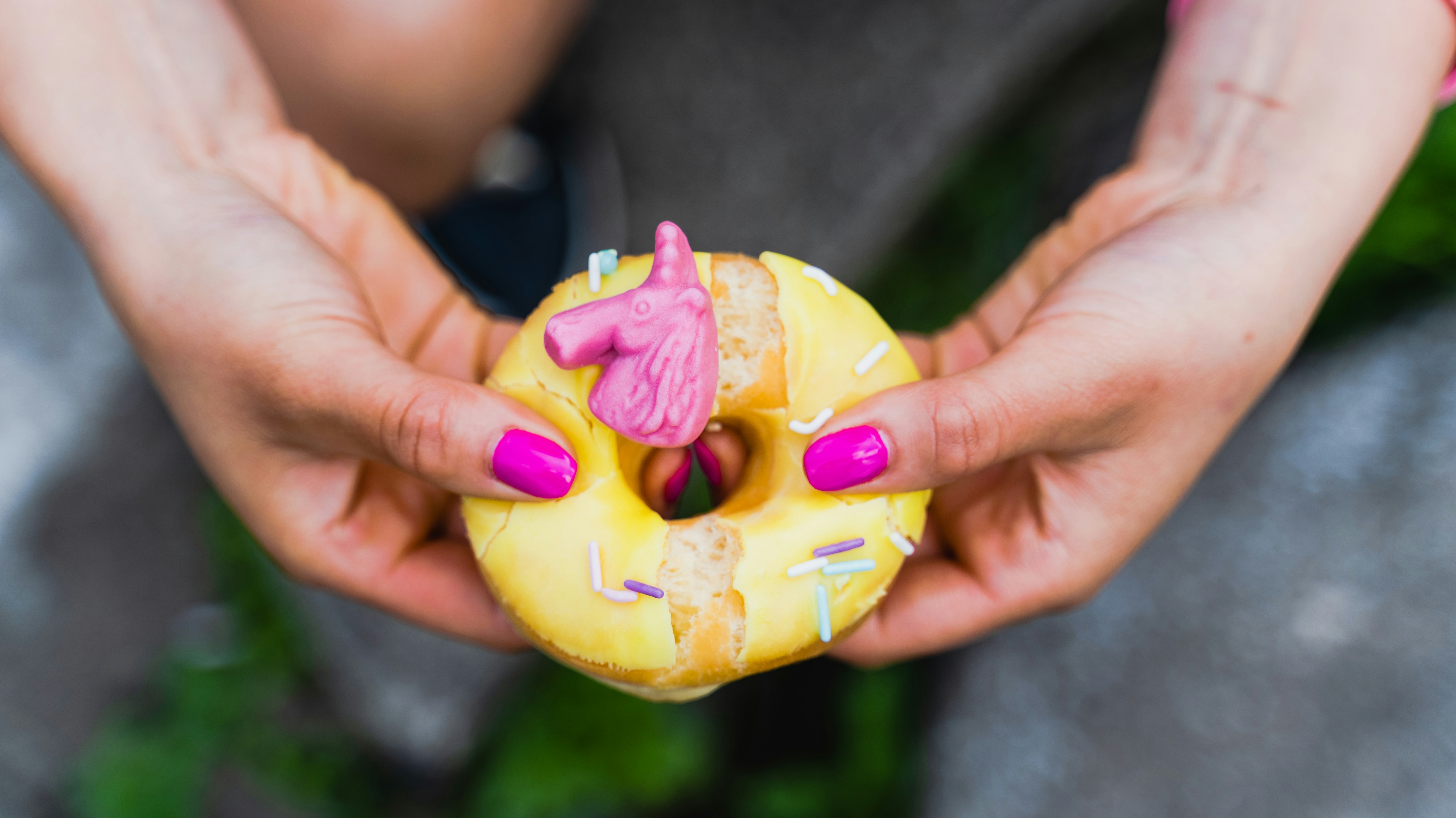 Candy Ring in Focus: Neon Nails Framing a Sprinkled Yellow Donut