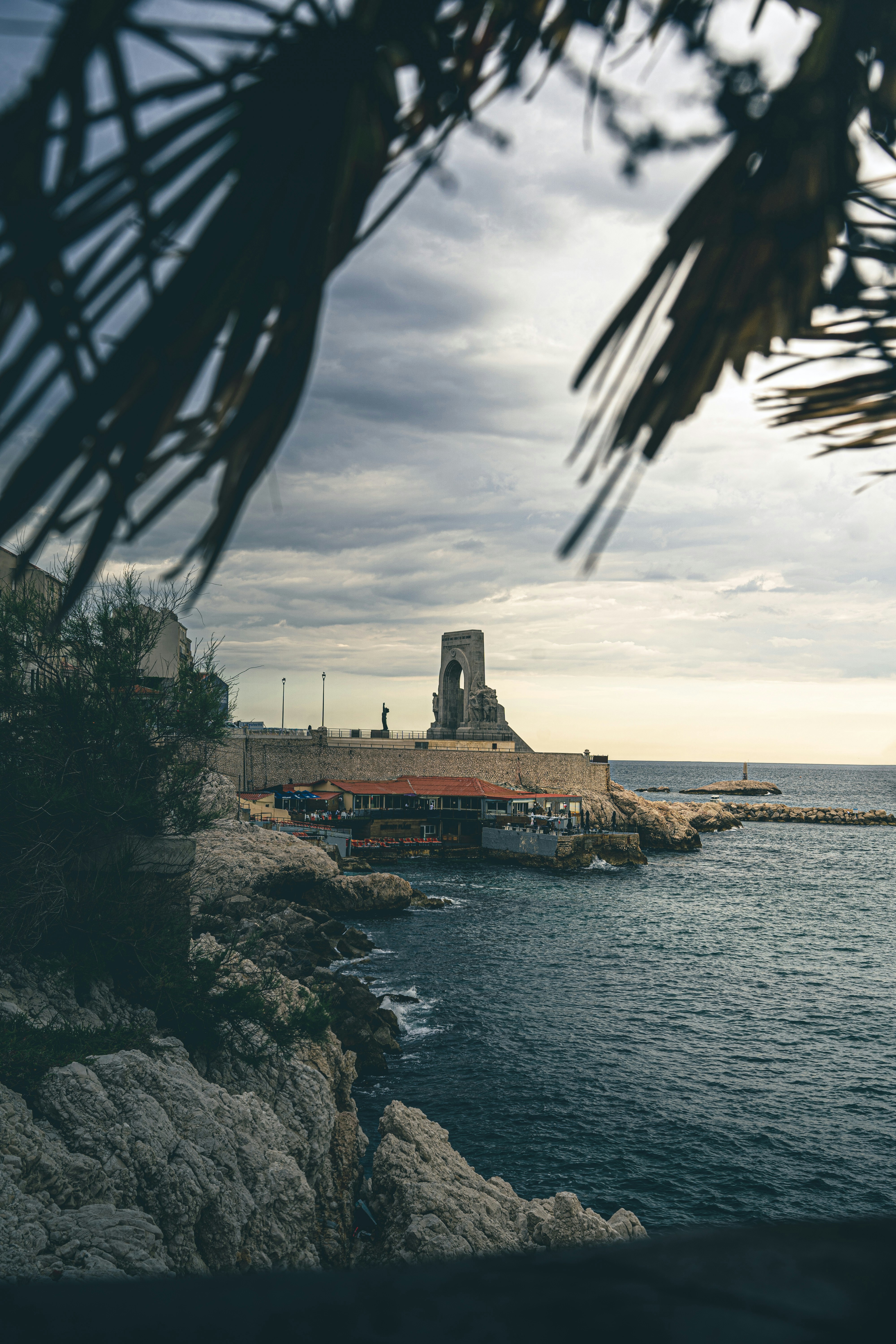 Frond-Framed Coastal Fortress Over a Quiet Sea