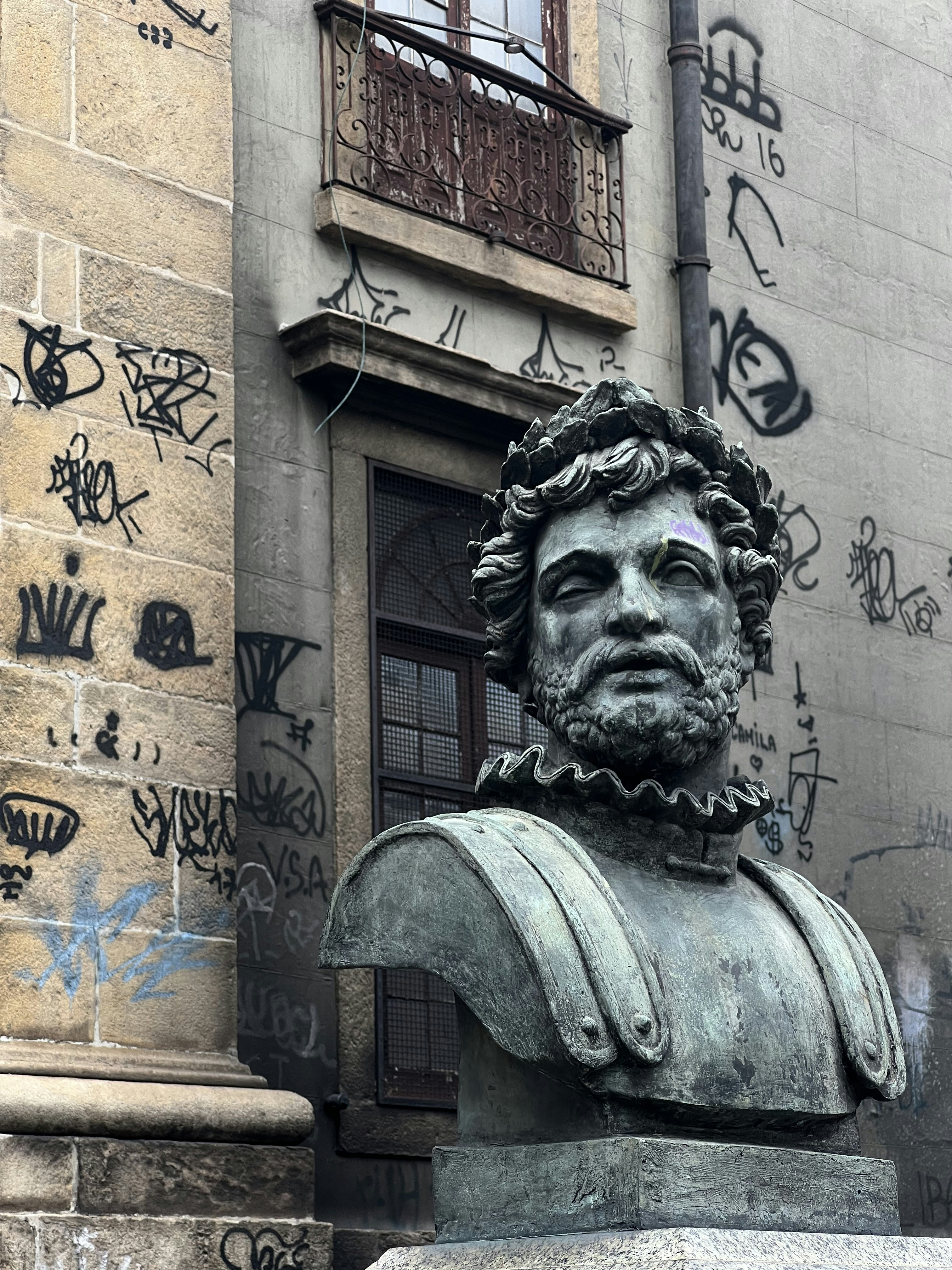 Bronze Bust Amid Street Graffiti: A Quiet Stare in the Urban Echo
