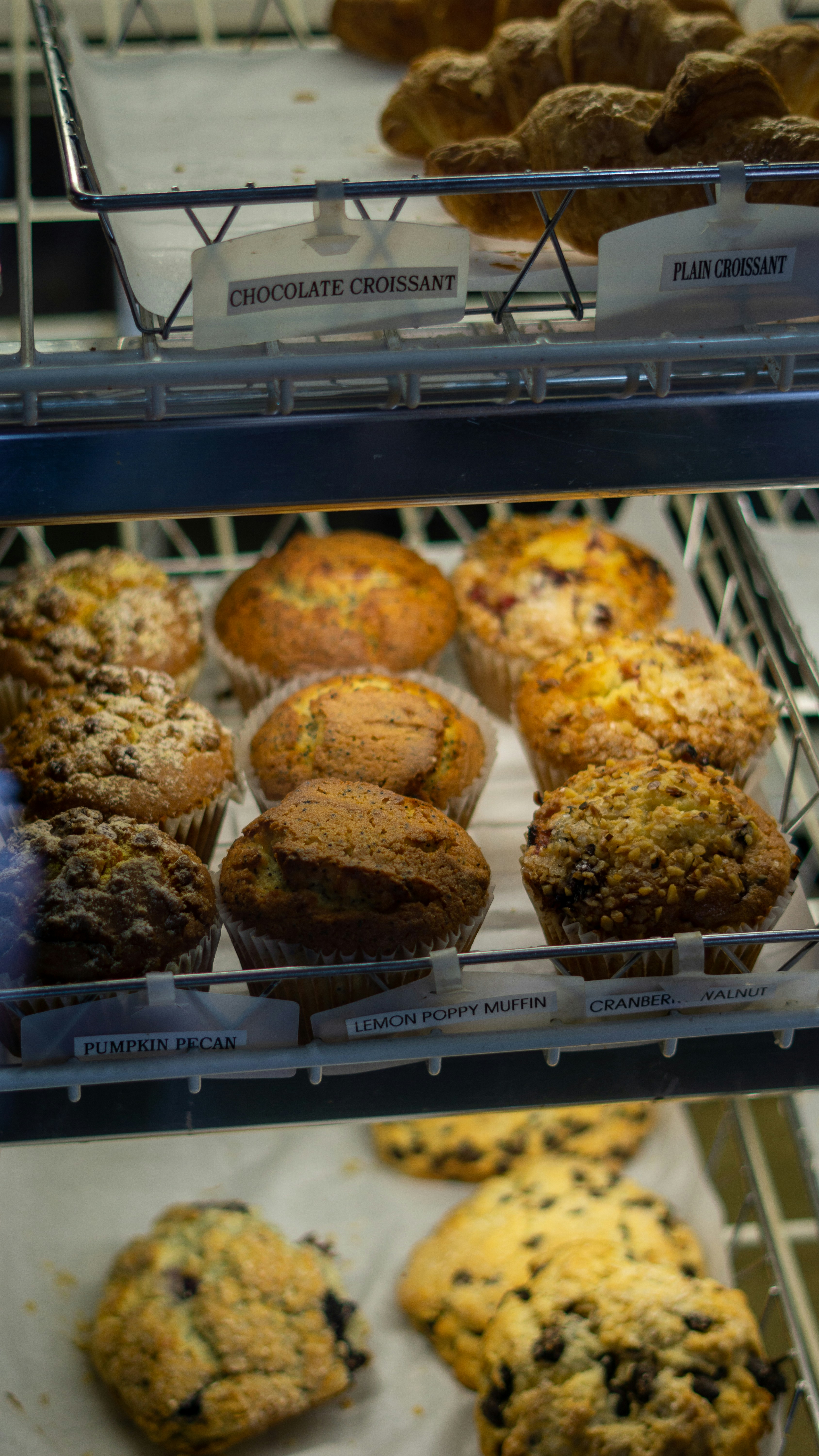 A display case filled with lots of different types of muffins photo ...