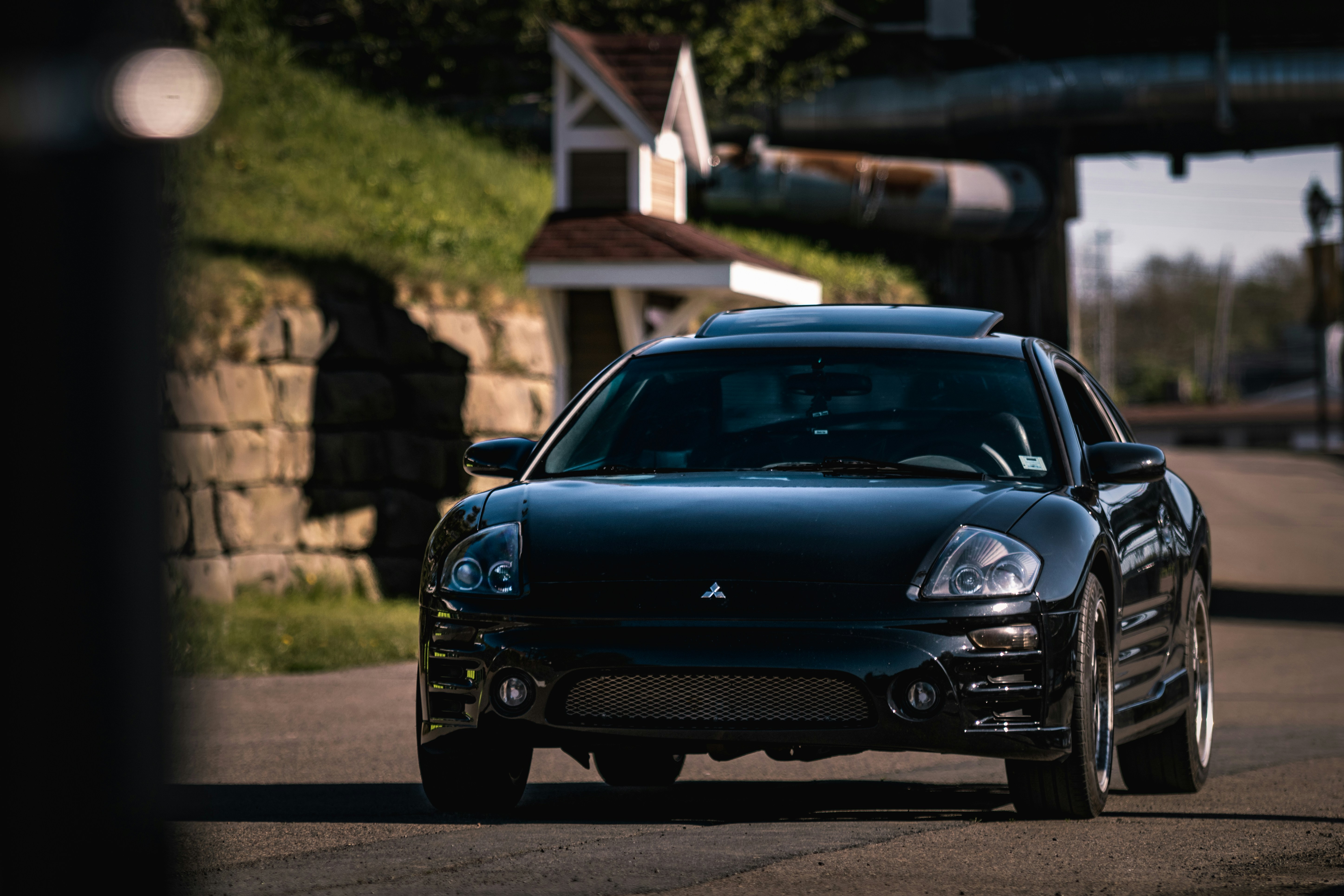 Mitsubishi Eclipse sports car cruising along a scenic road, showcasing its dynamic design and performance features.