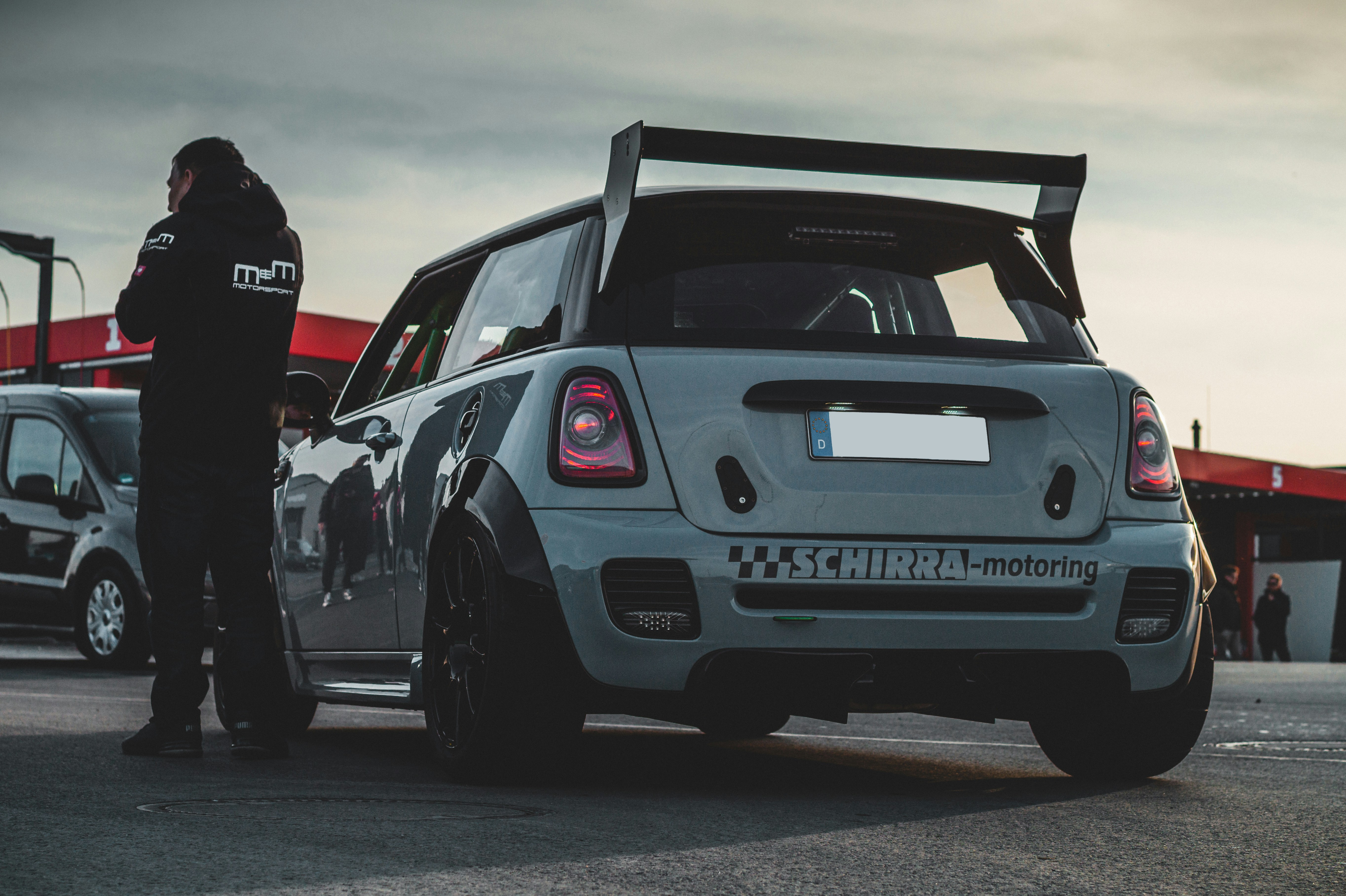 A man standing next to a mini cooper cooper cooper cooper cooper cooper ...