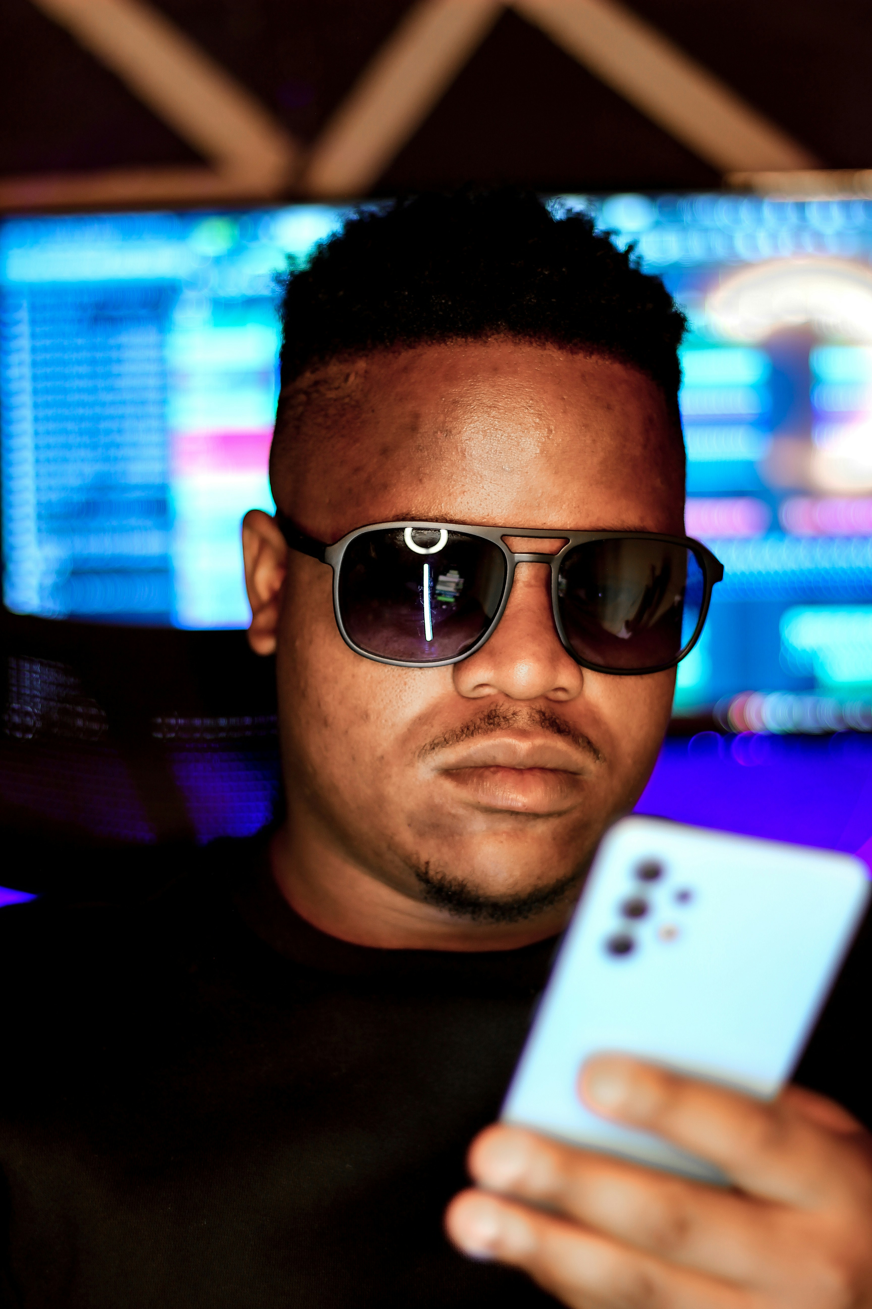 A man wearing sunglasses holding a cell phone photo – Free Dj tears plk ...