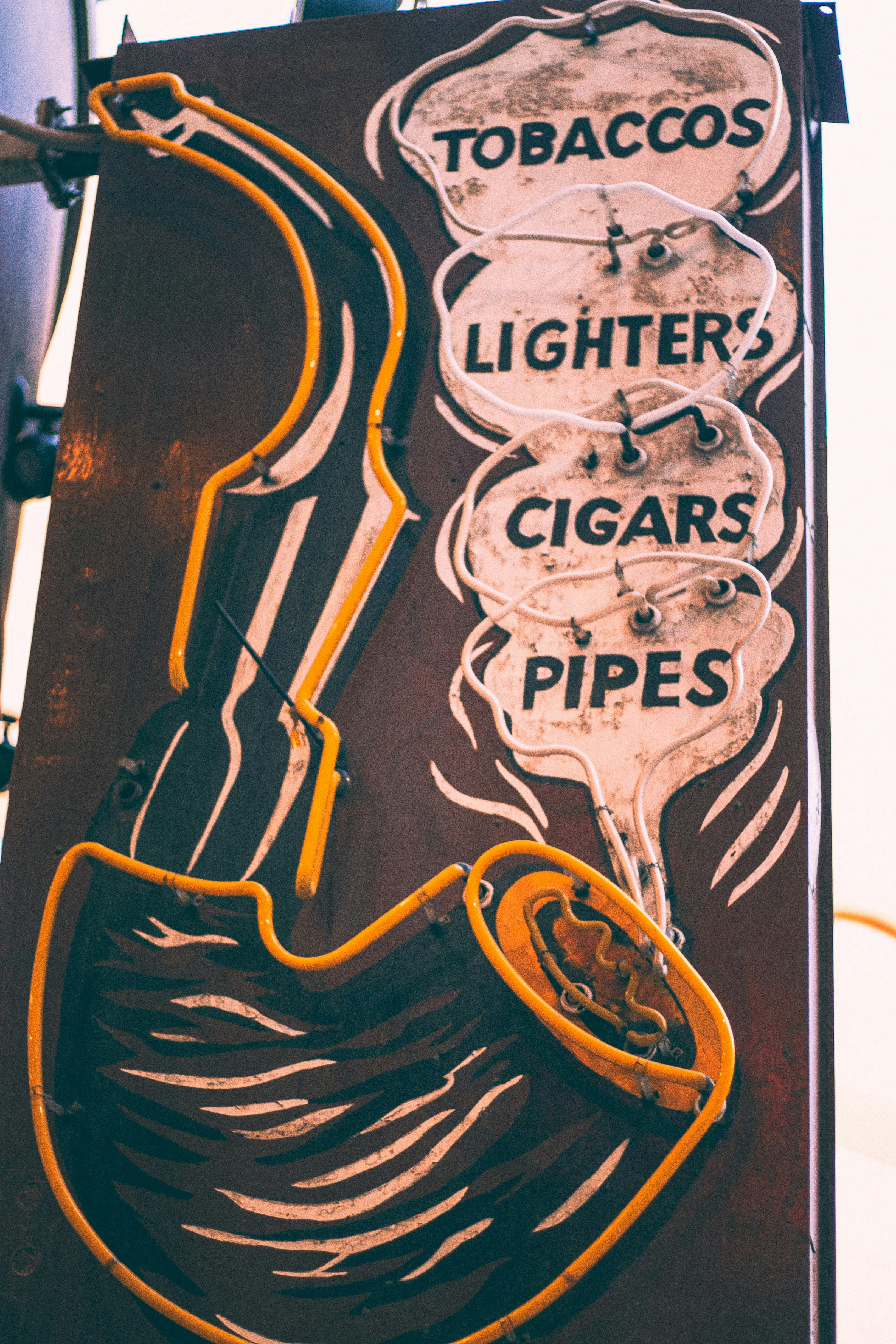 Neon-Tubed Hand Grasping a Weathered Tobacco Sign