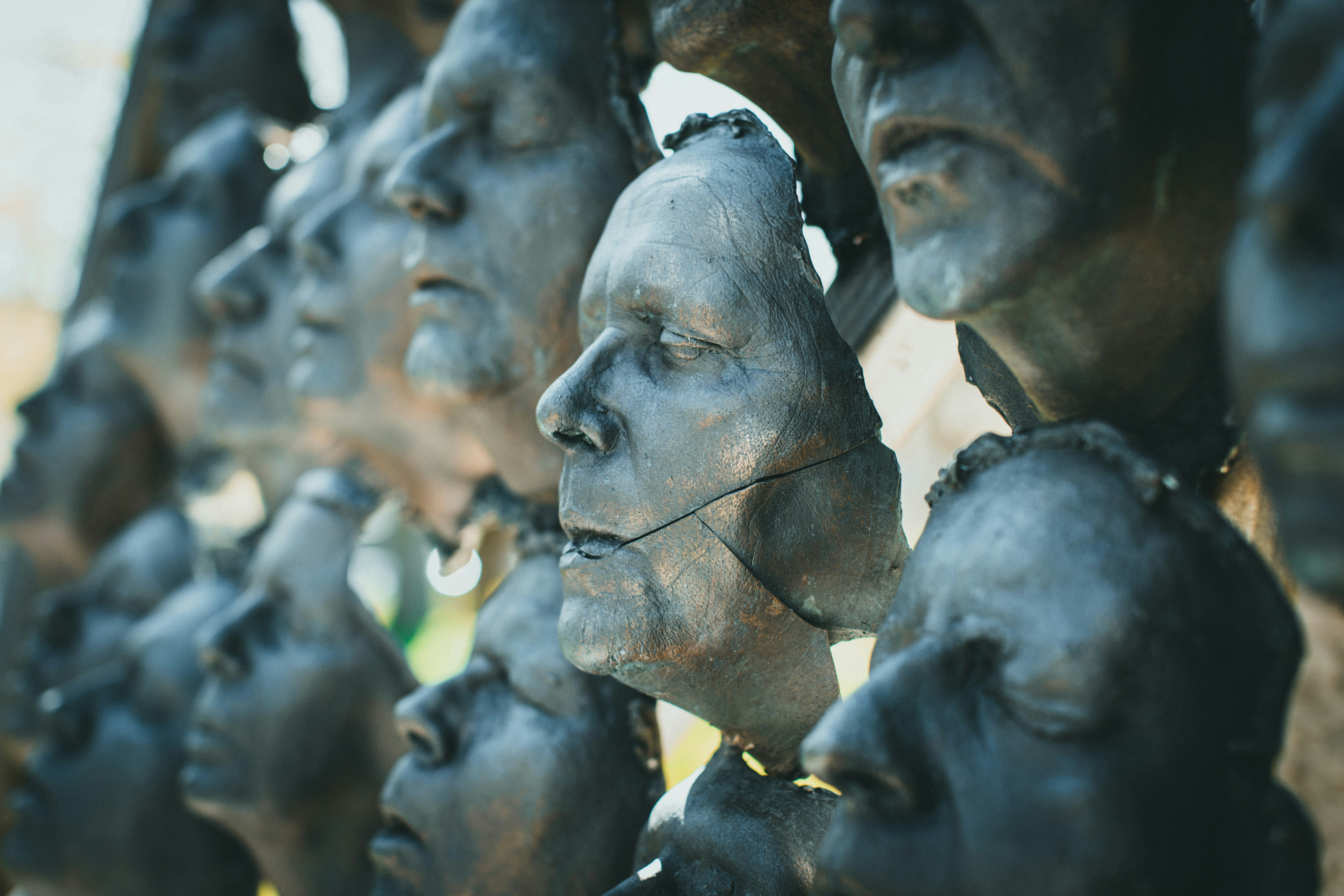 A close up of a group of statues of heads photo – Free St. john's Image ...