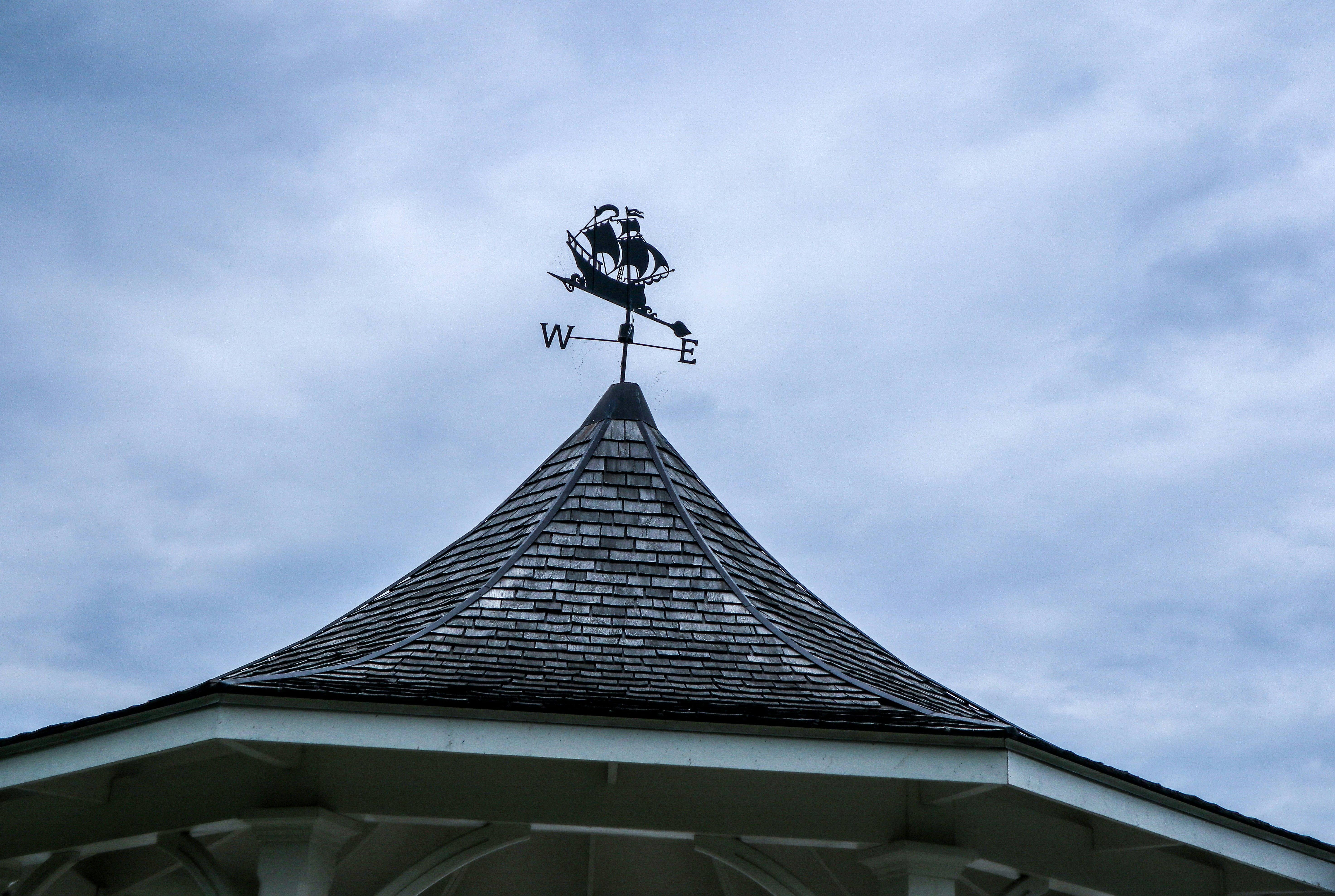 A weather vane on top of a roof photo – Free Wallpaper hd Image on Unsplash