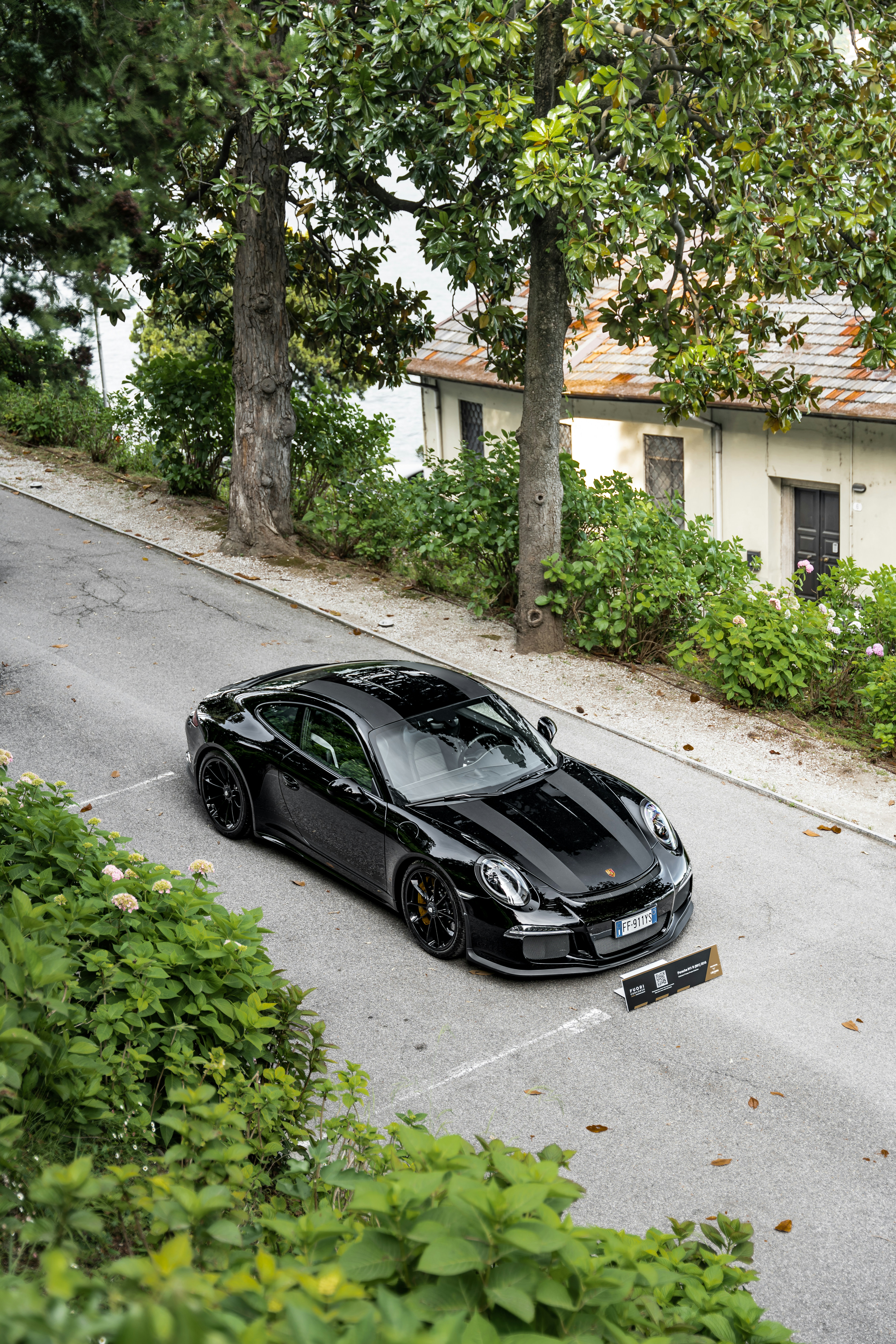 Gloss on Asphalt: A Black Porsche 911 on a Quiet Tree-Framed Hill Road