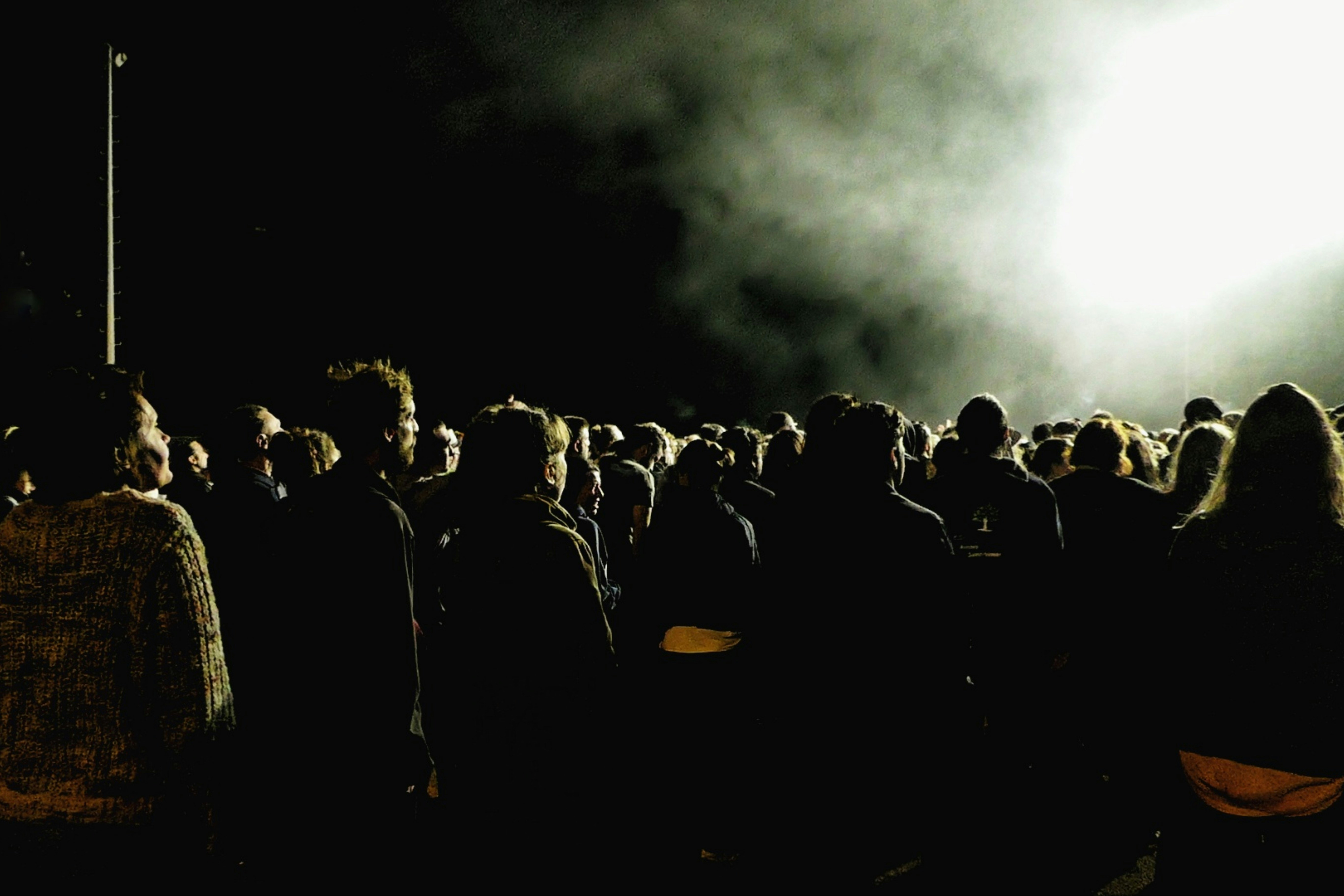 A large group of people standing in the dark photo – Free Person Image ...