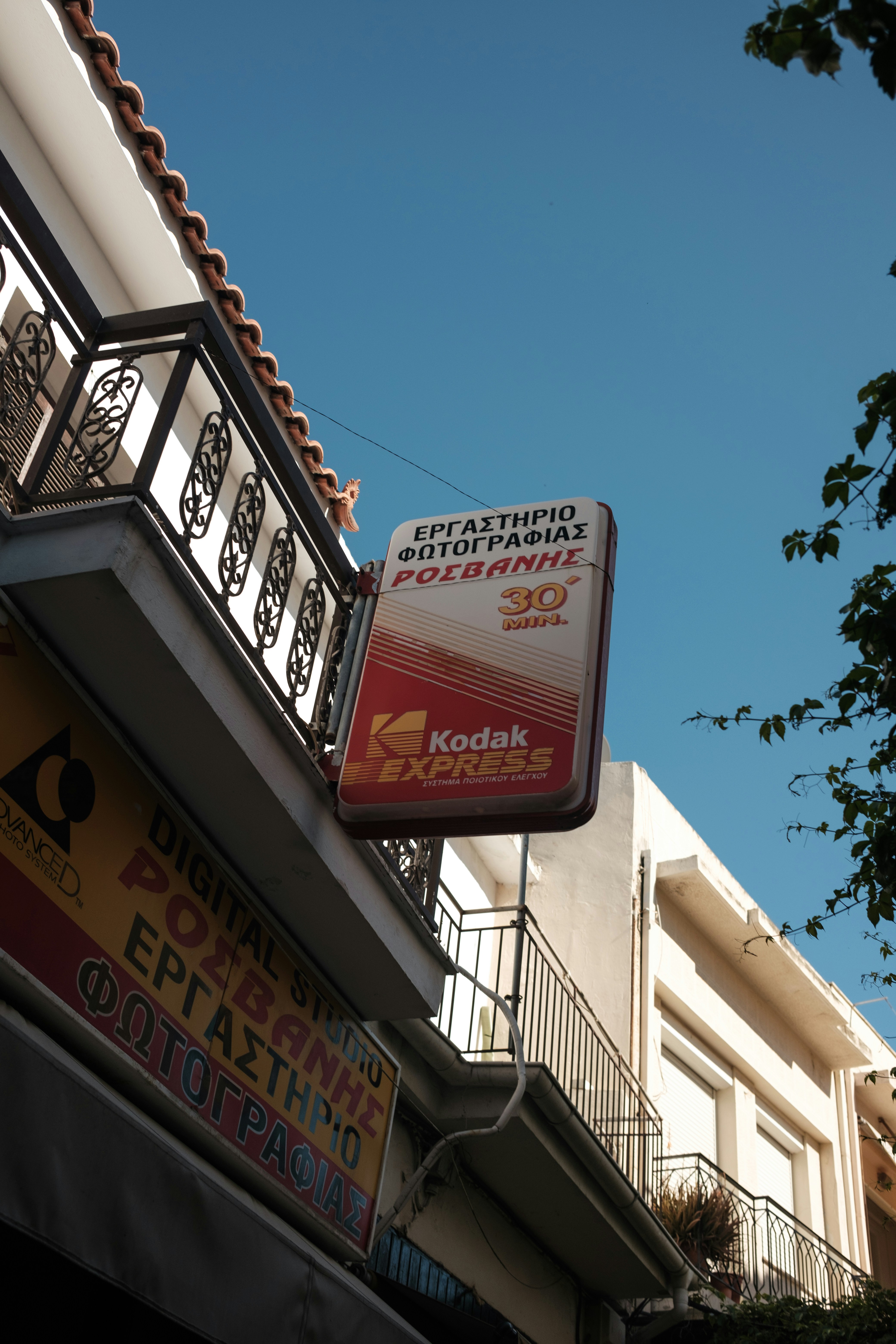 Kodak Express Sign Anchors a Greek Street Under a Clear Sky