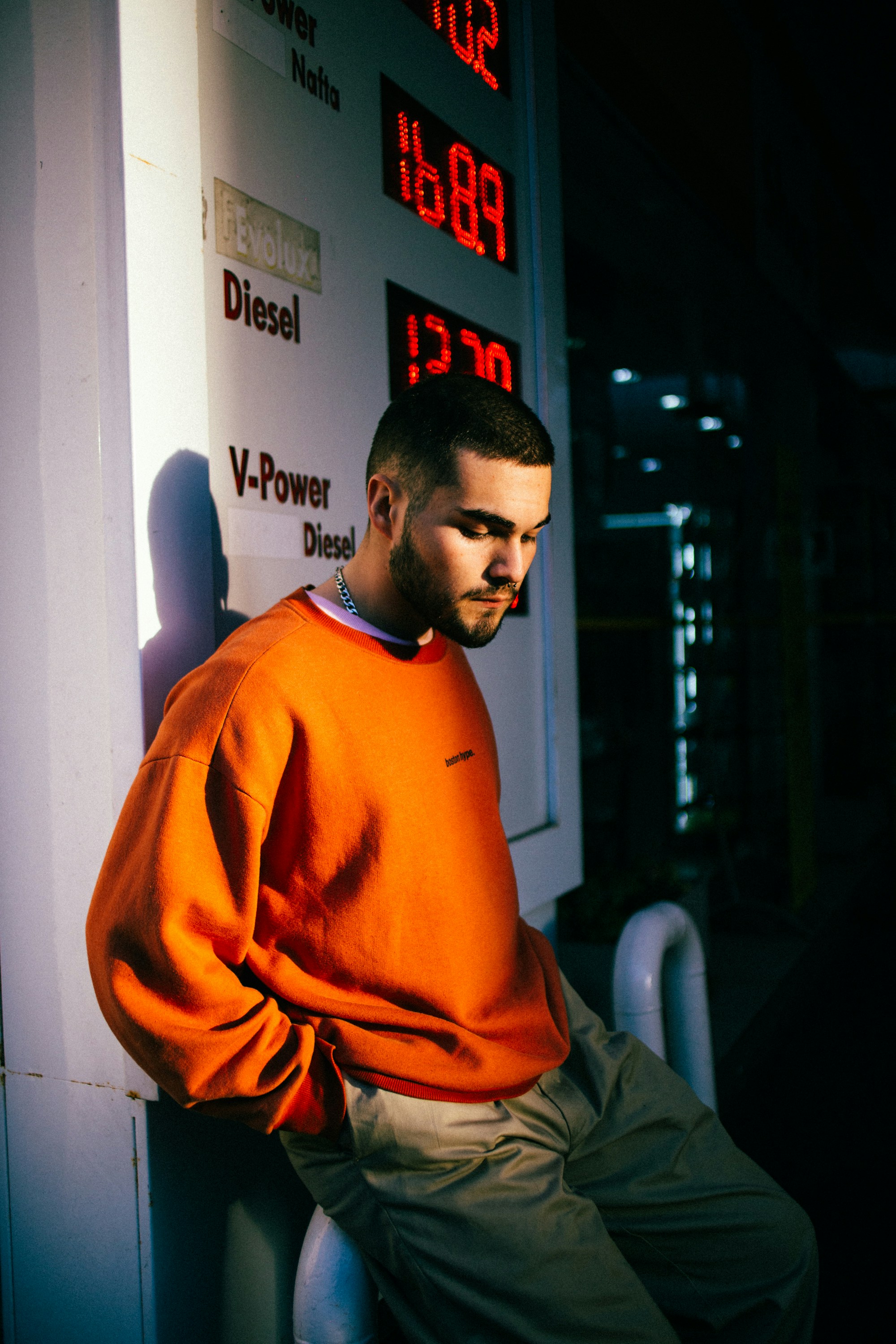 Orange Sweatshirt Quiet: A Night Shift by the Diesel Sign