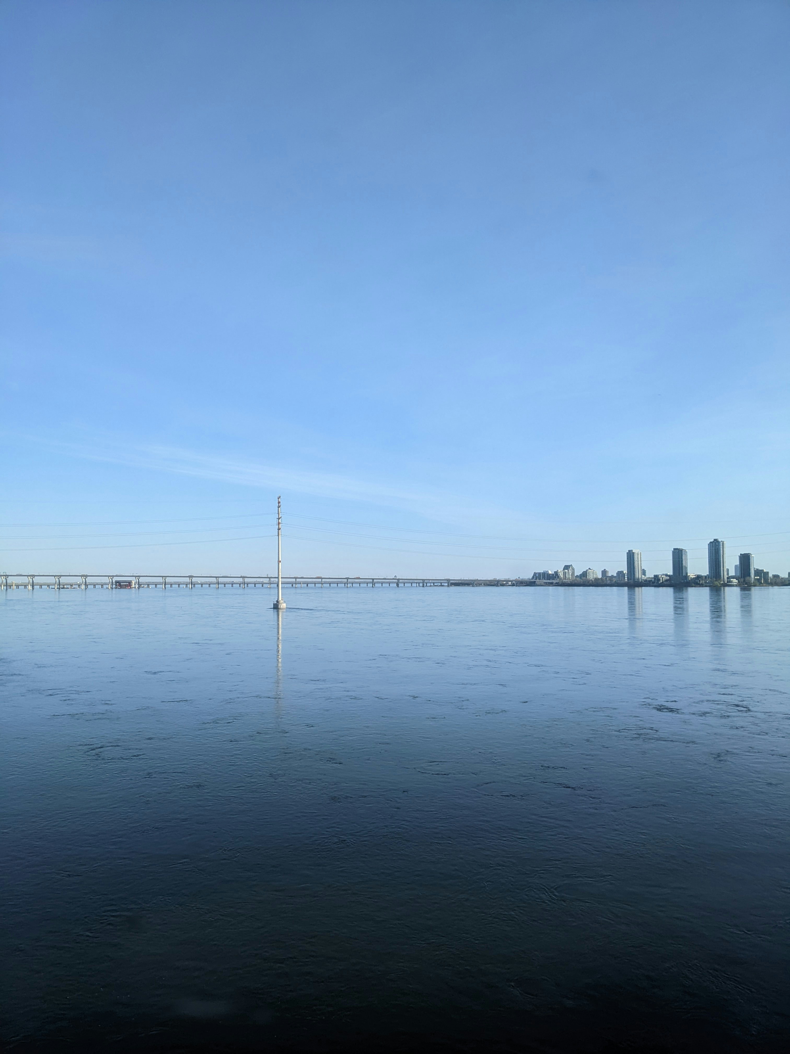 Calm Horizon: Urban Skyline Reflected Across Still Water